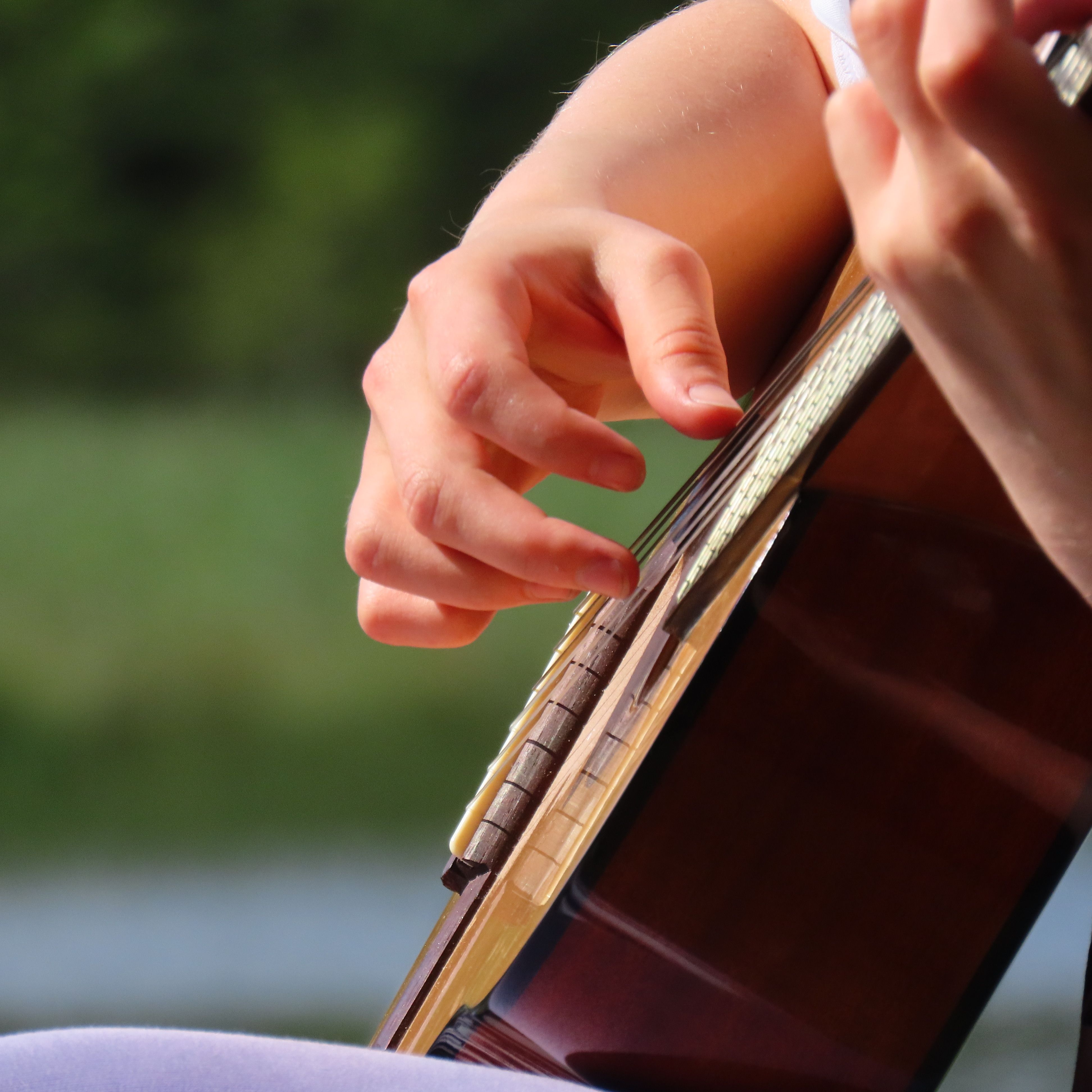Close-up of a Guitarist Playing Outdoors · Free Stock Photo