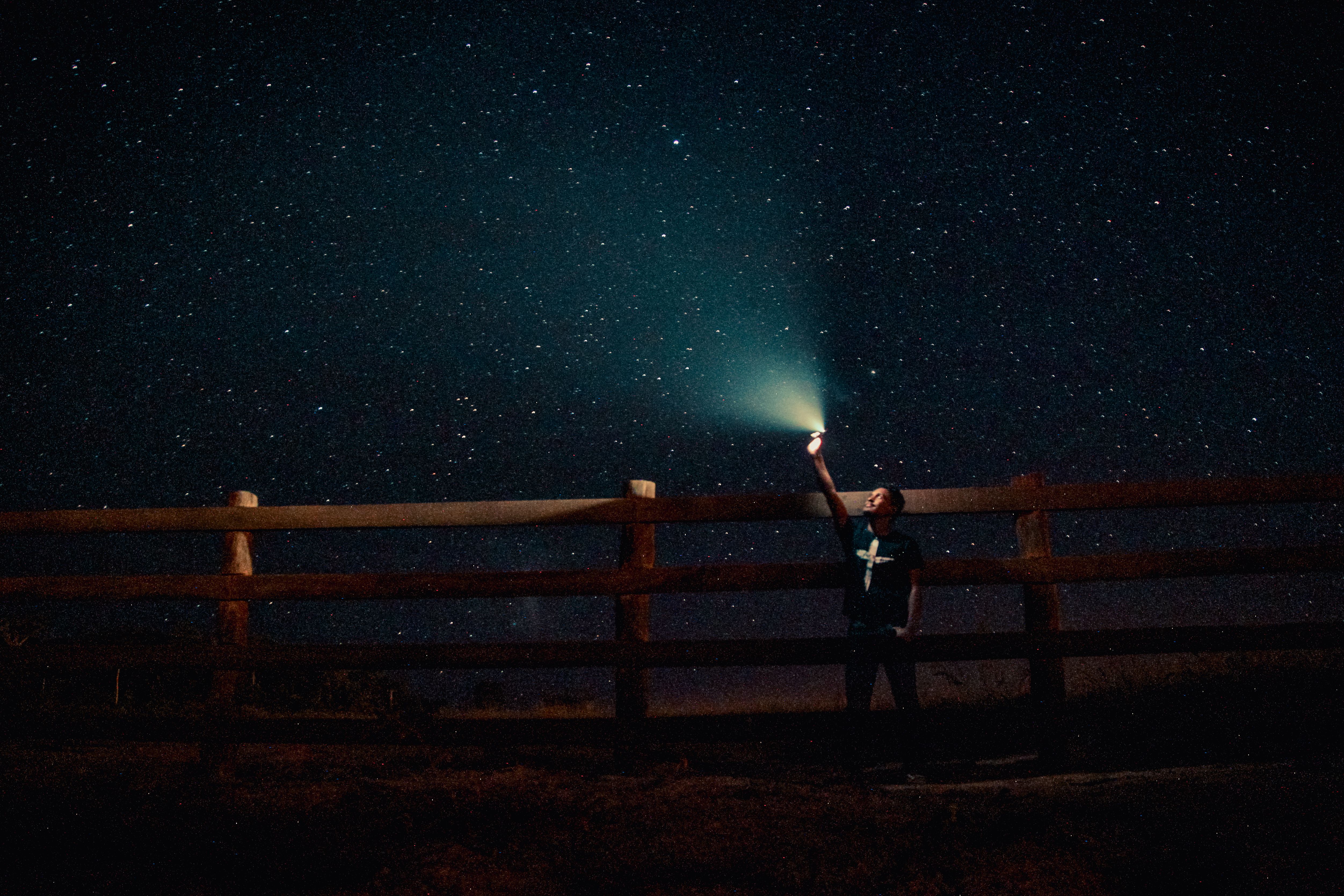 Person Shining Flashlight Under Starry Night Sky · Free Stock Photo
