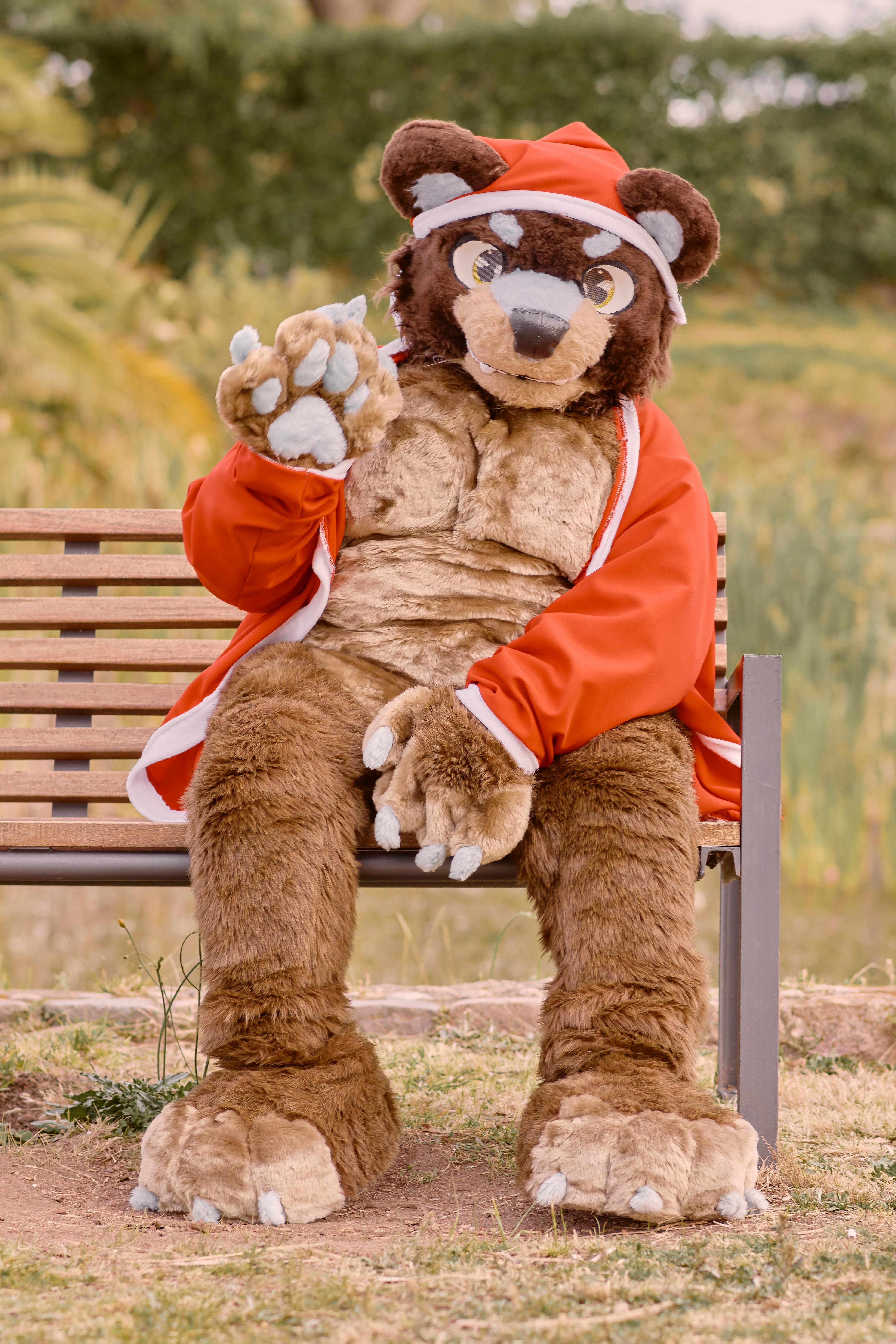 Furry Character in Costume Waving on Park Bench · Free Stock Photo