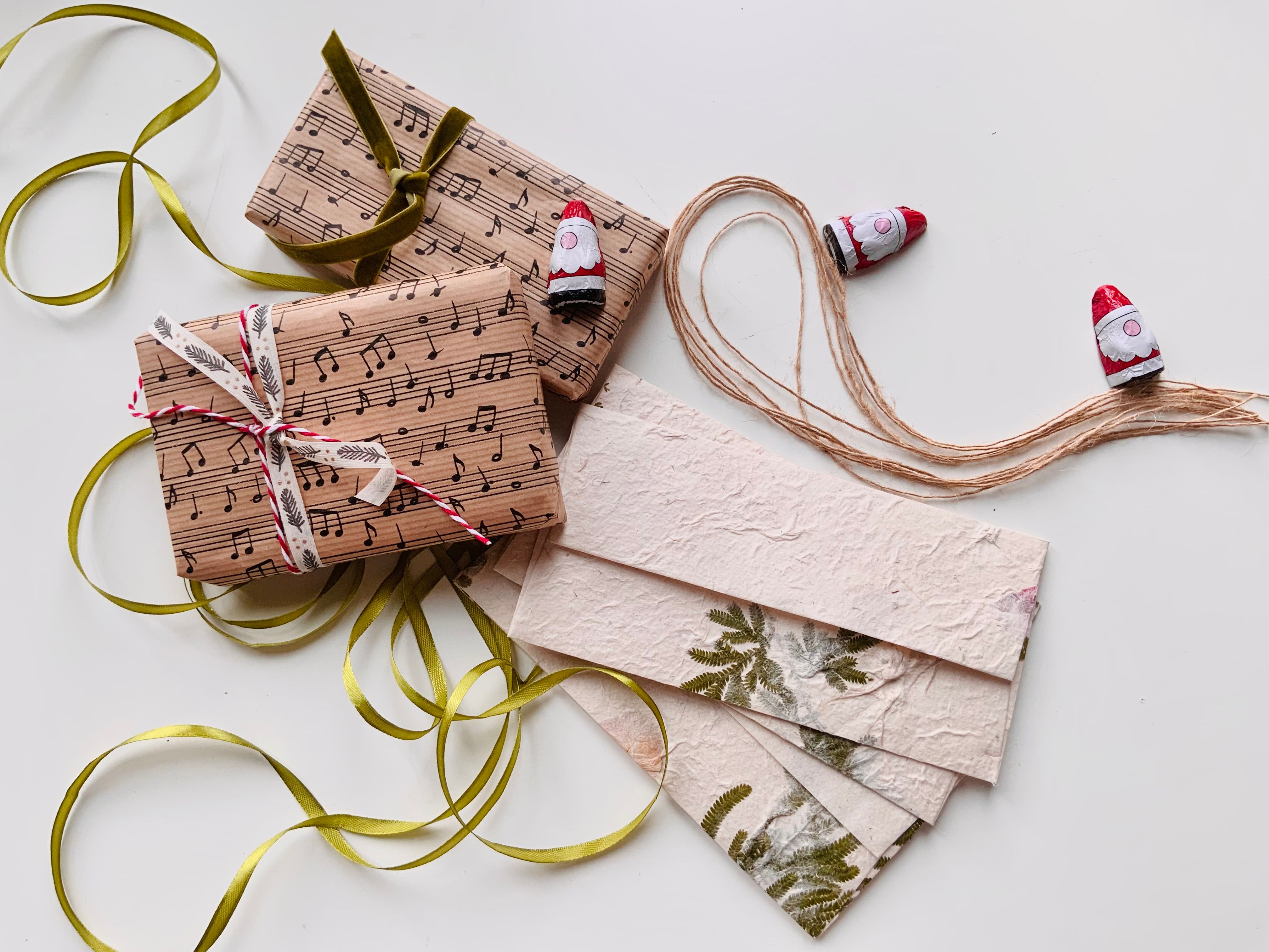 Festive Gift Wrapping with Musical Note Paper and Gnomes · Free Stock Photo