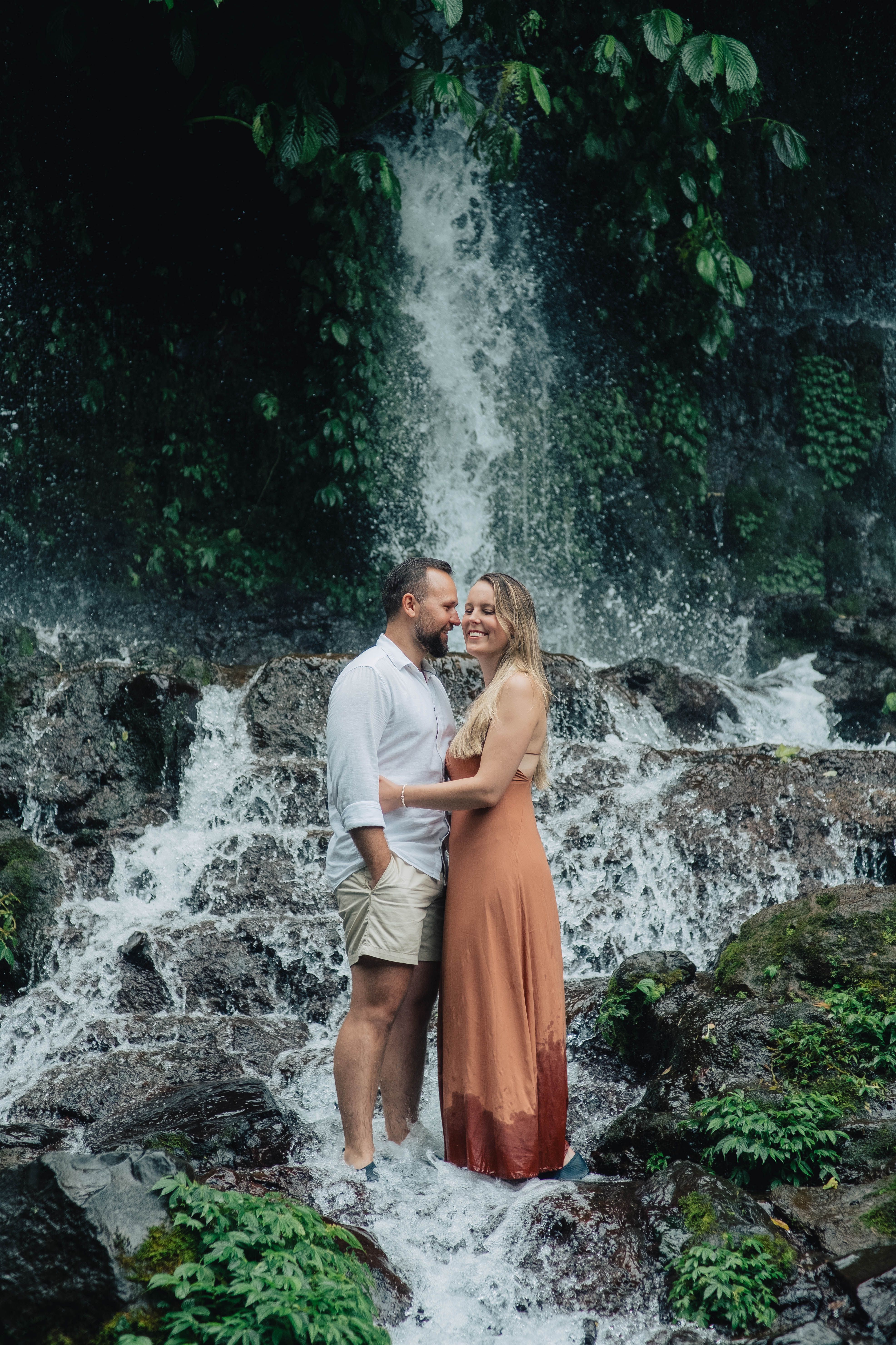 Romantic couple embracing by a waterfall · Free Stock Photo