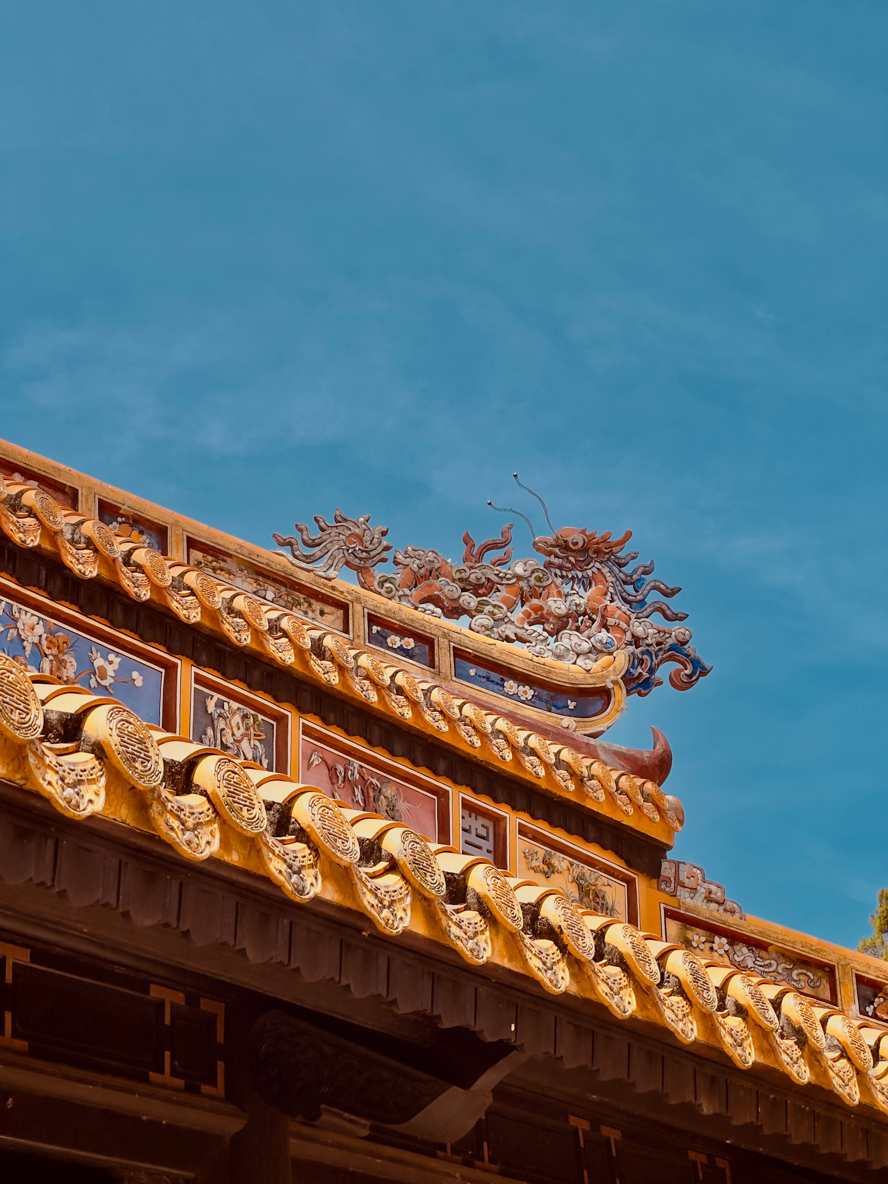 Ornate Asian Architectural Roof Detail Under Clear Sky · Free Stock Photo