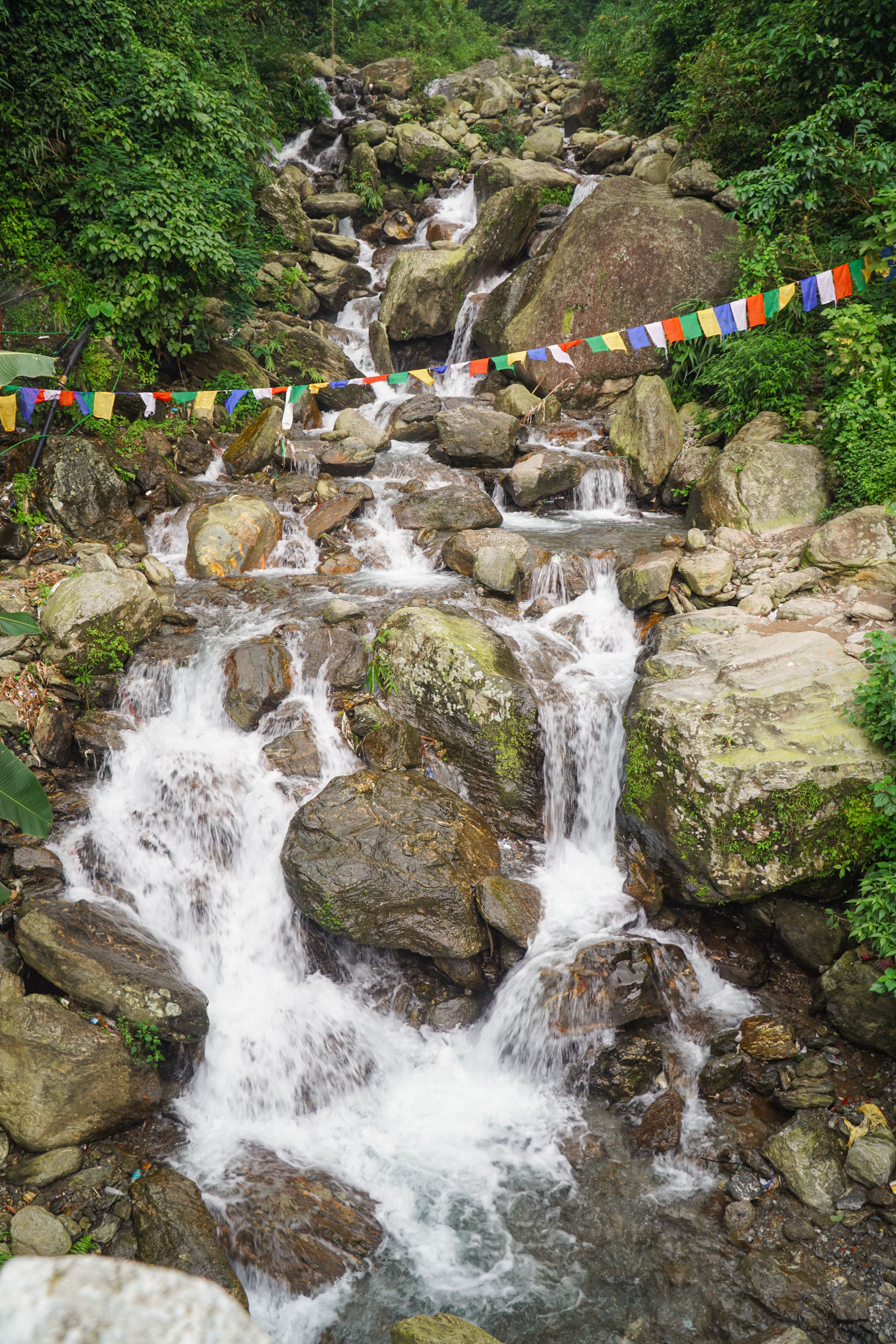 Scenic Waterfall with Prayer Flags in Darjeeling · Free Stock Photo