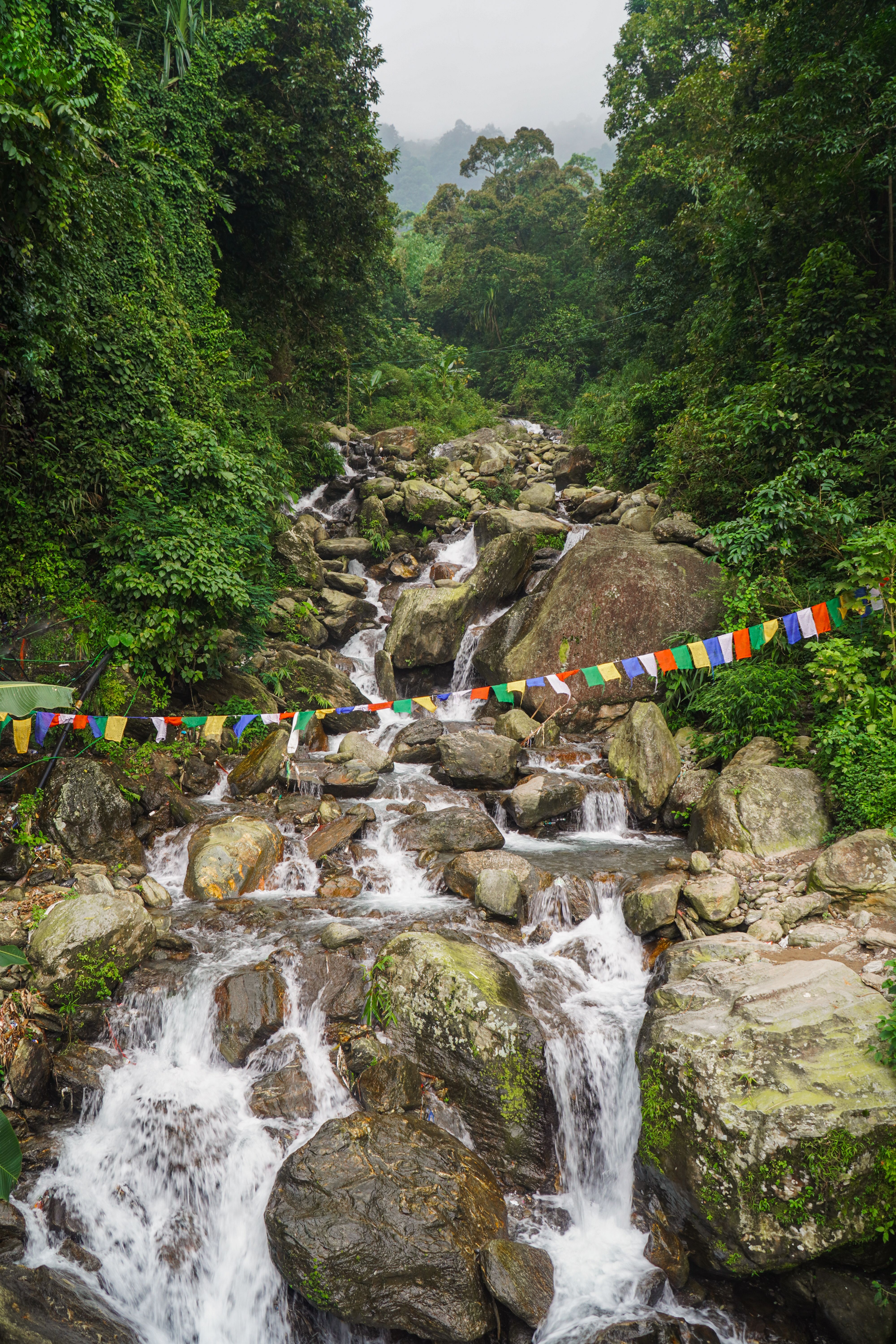 Scenic Waterfall with Prayer Flags in Darjeeling · Free Stock Photo