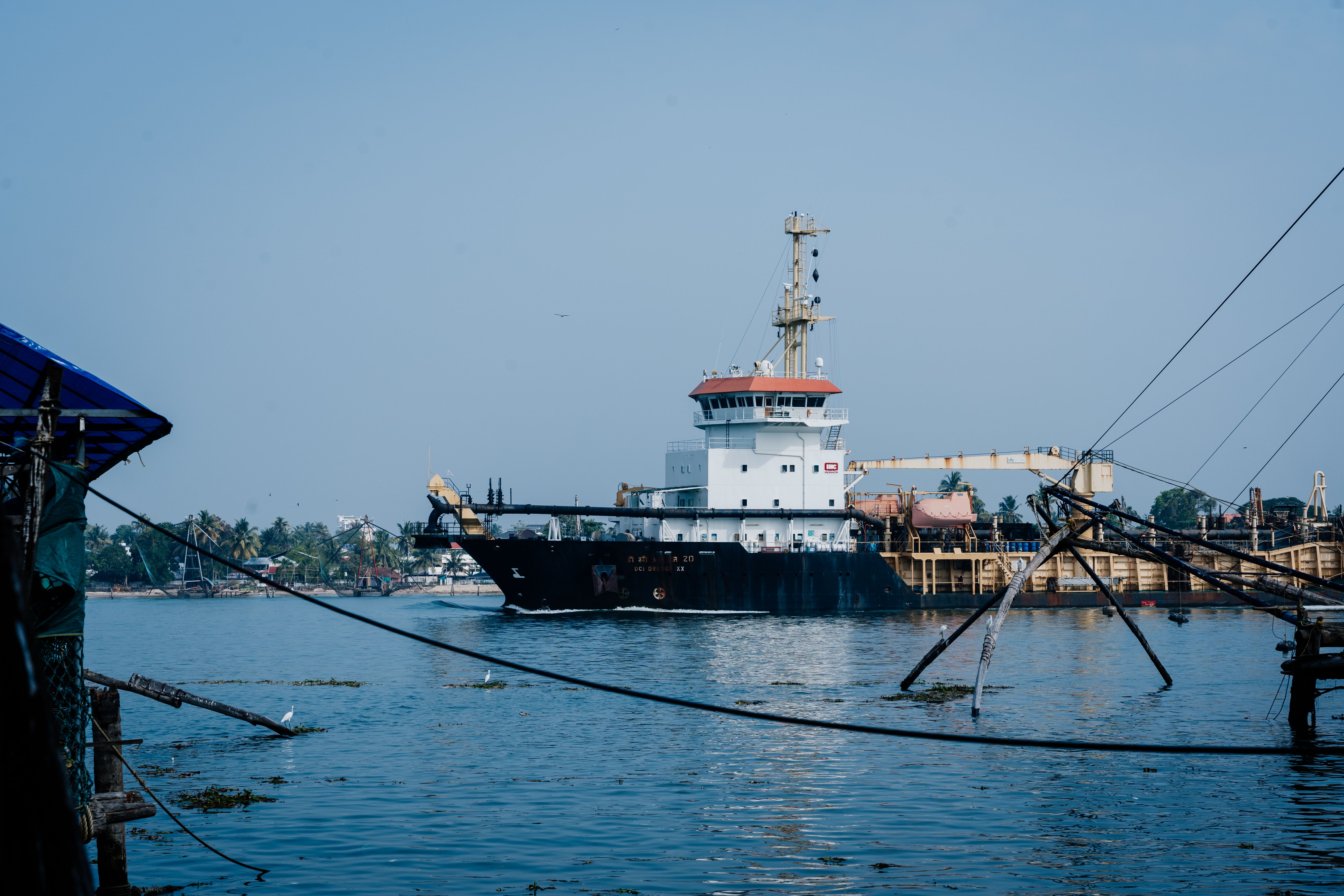 Cargo Ship Docked Near Iconic Chinese Fishing Nets · Free Stock Photo