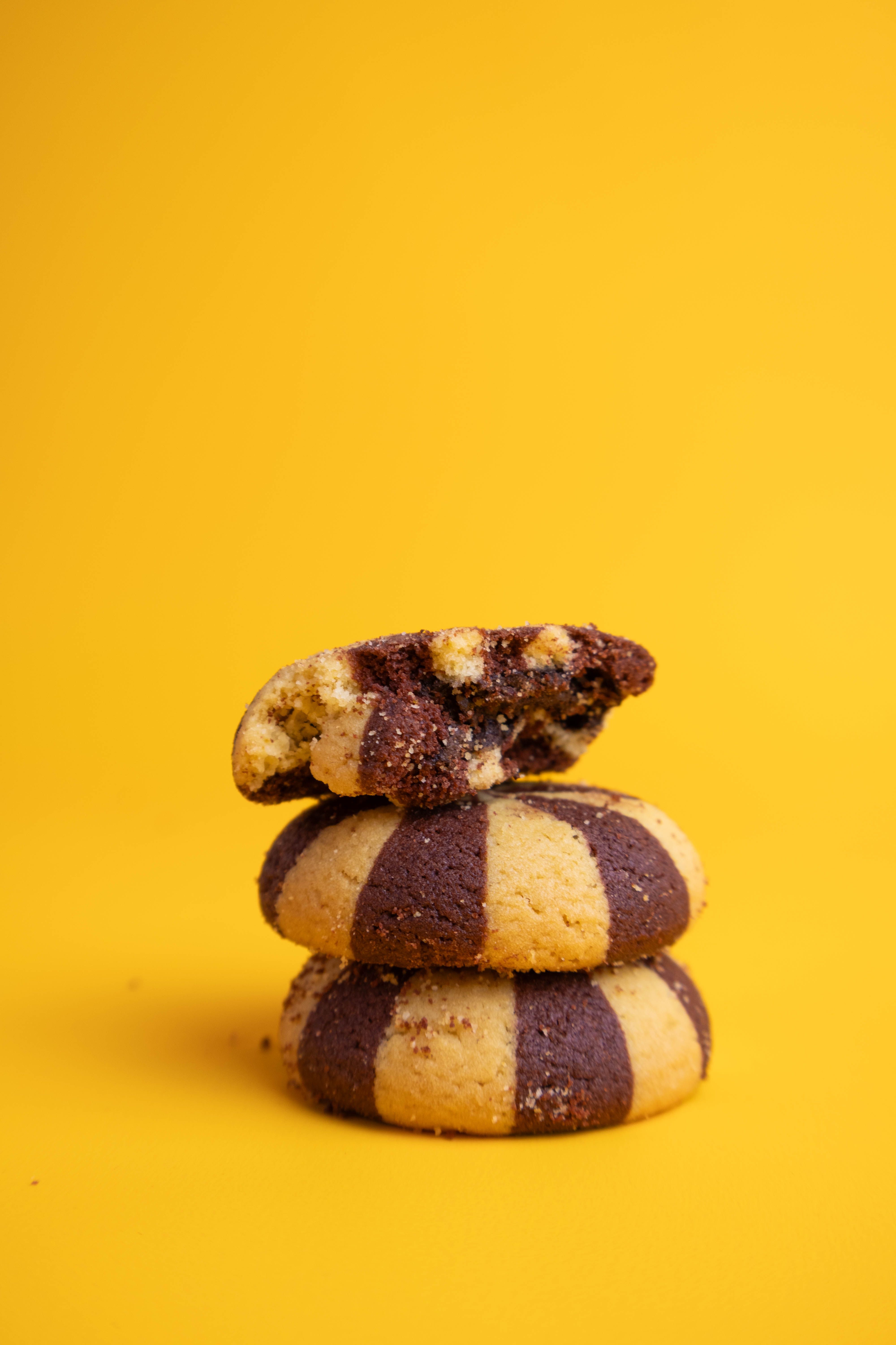 Stack of Marble Cookies on Vibrant Yellow Background · Free Stock Photo