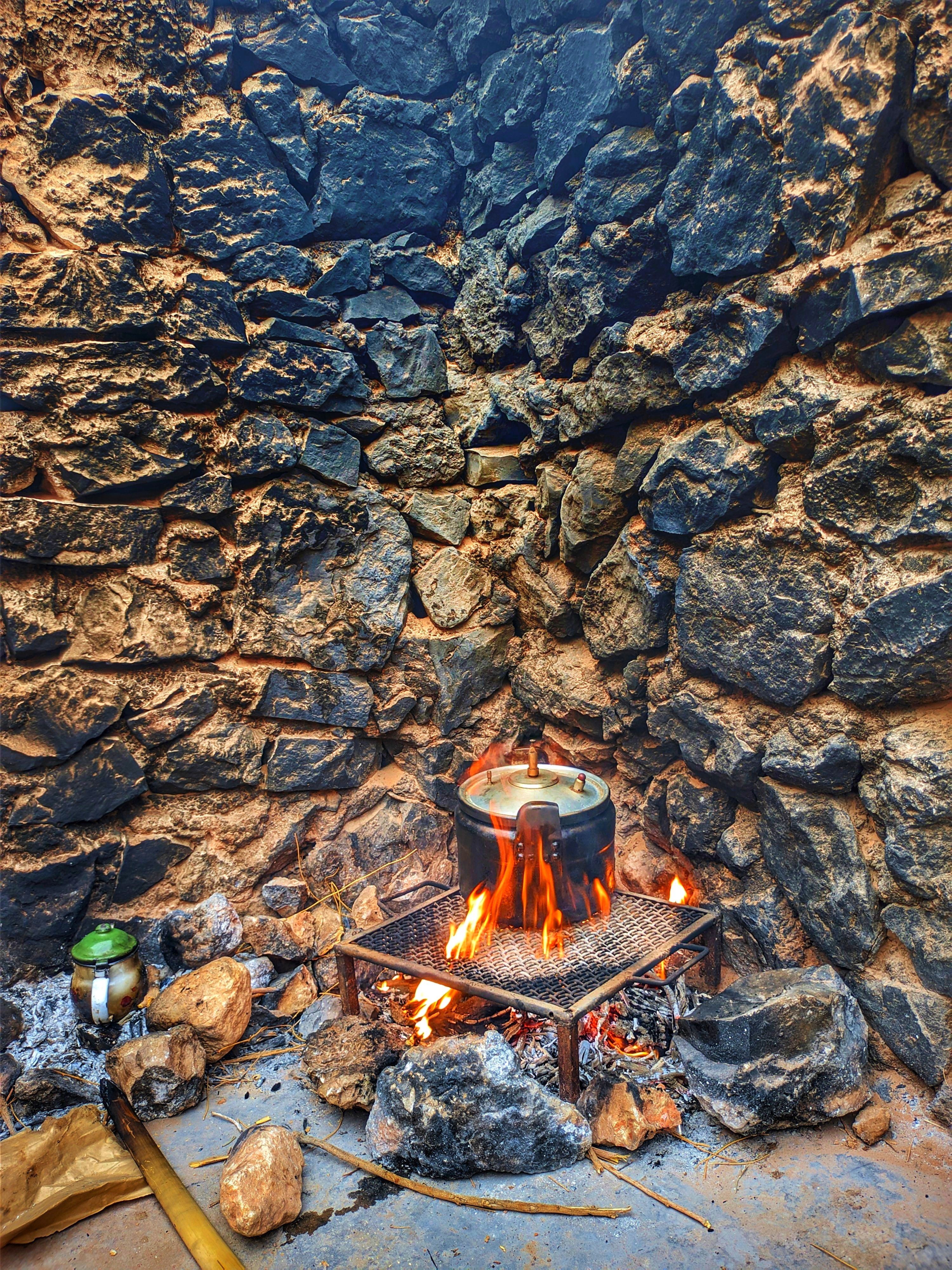 Outdoor Cooking Over Open Fire in Rustic Setting · Free Stock Photo