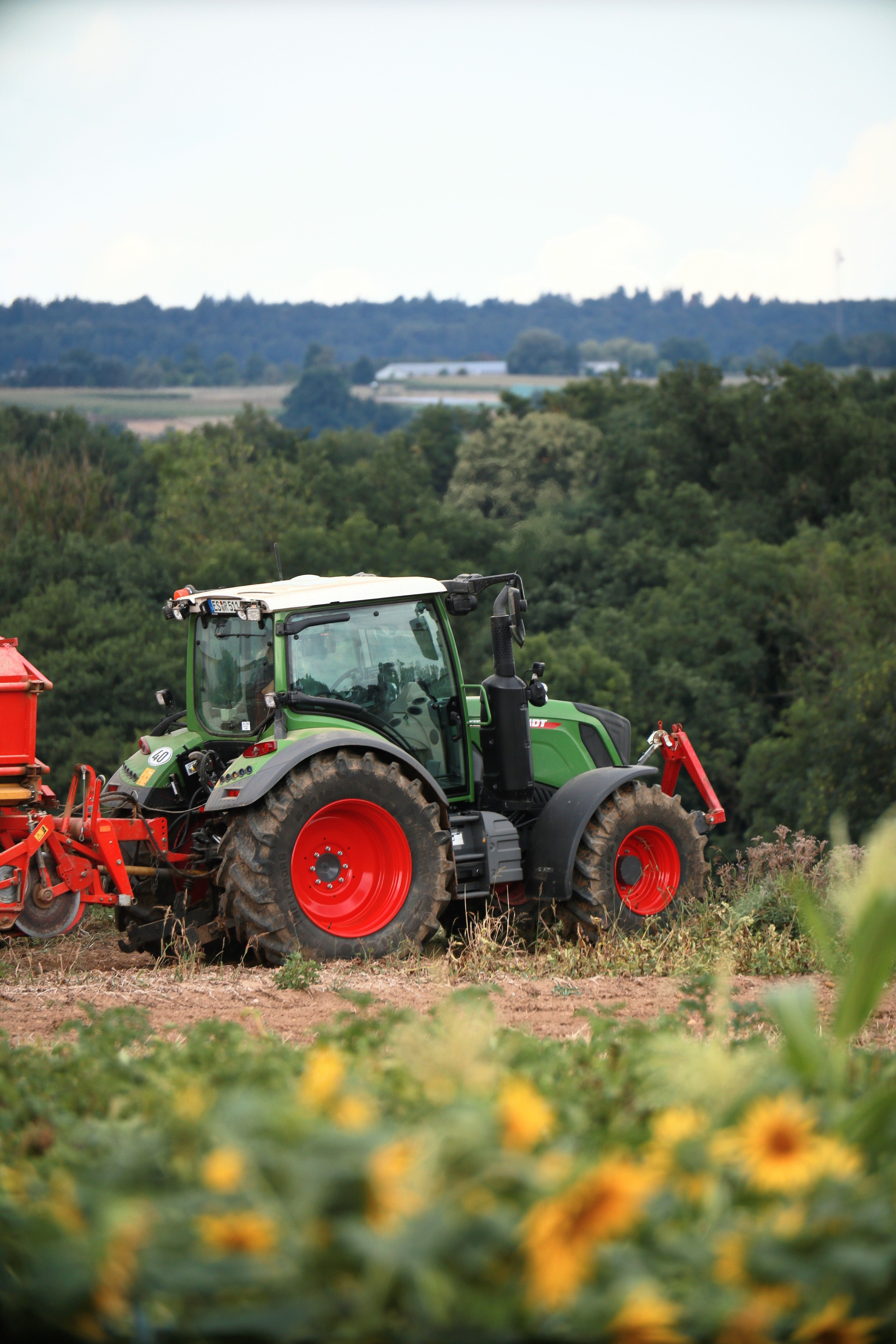 Colorful Agricultural Tractor in Scenic Field · Free Stock Photo