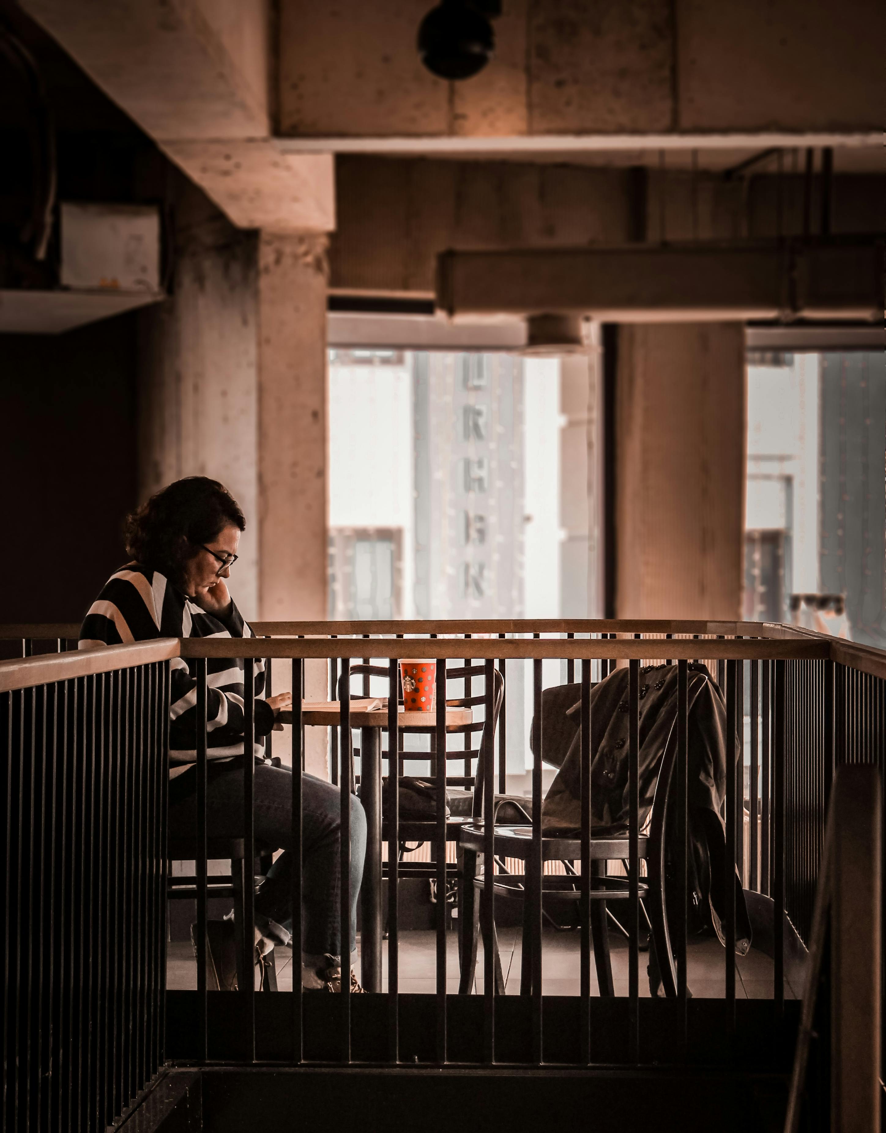 Lonely woman with book and coffee in cafe · Free Stock Photo