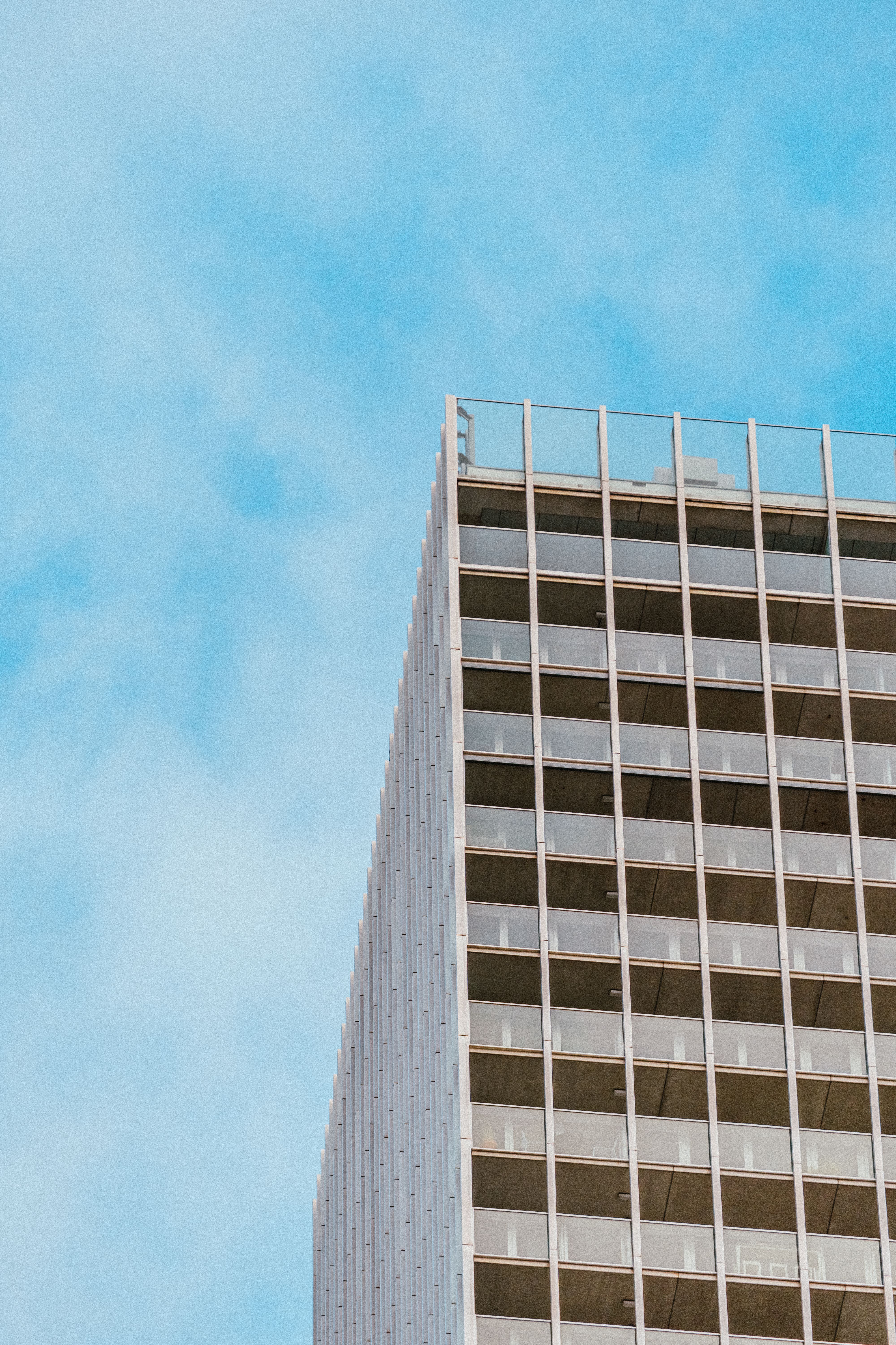 Modern High-Rise Building Against Clear Blue Sky · Free Stock Photo
