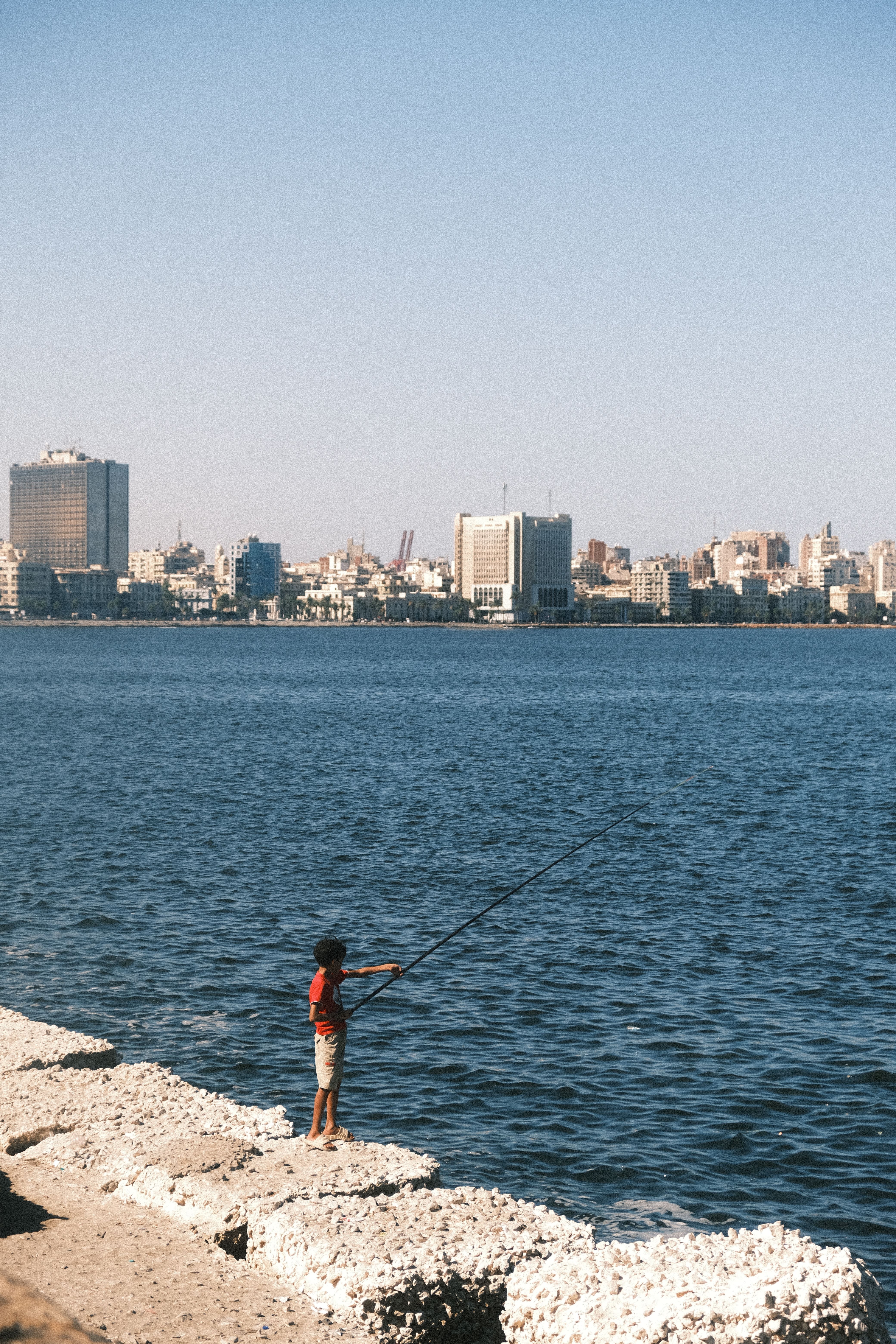 Child Fishing on Alexandria Coastline in Summer · Free Stock Photo