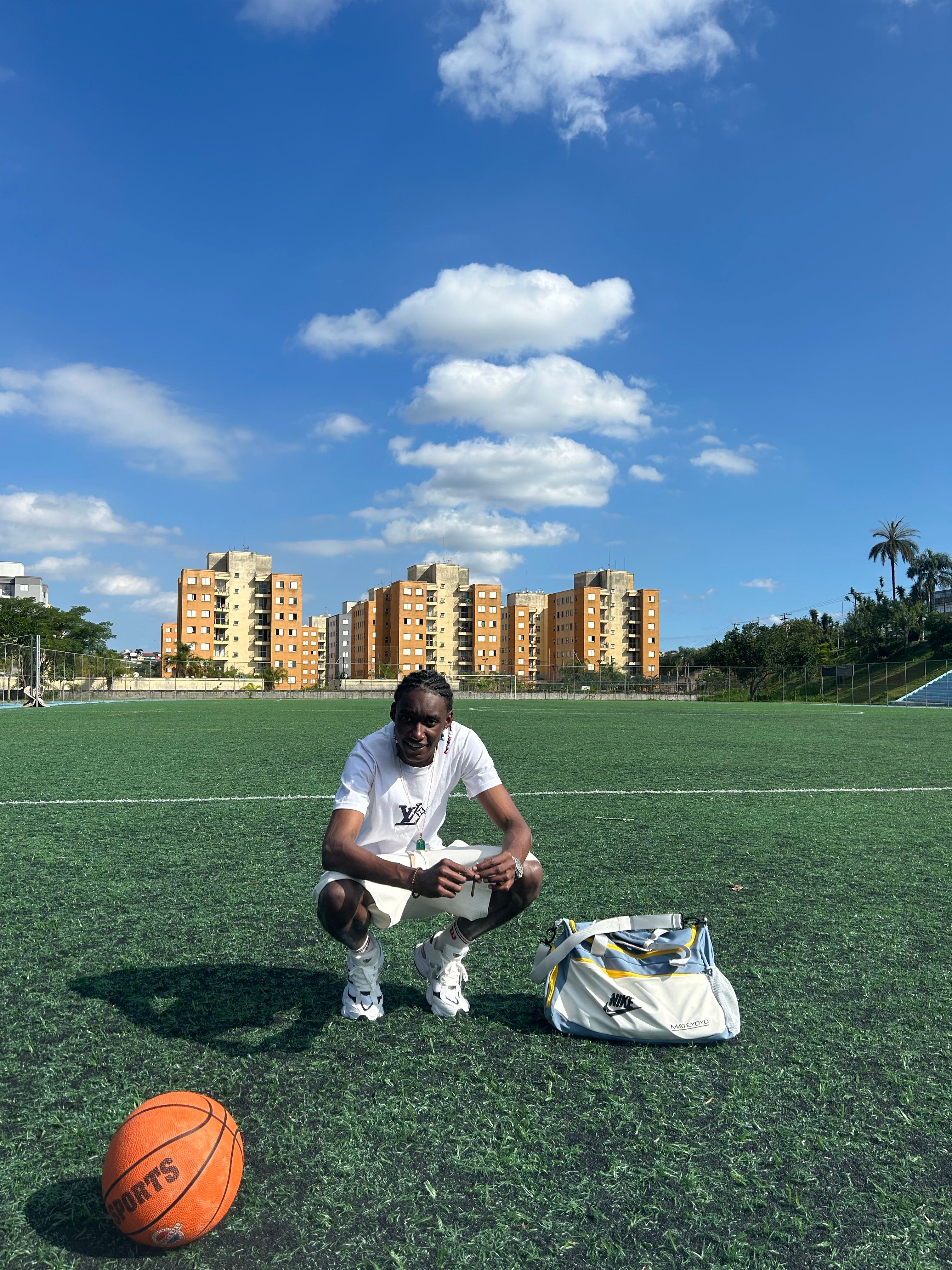 Athlete Resting on Soccer Field with Basketball · Free Stock Photo