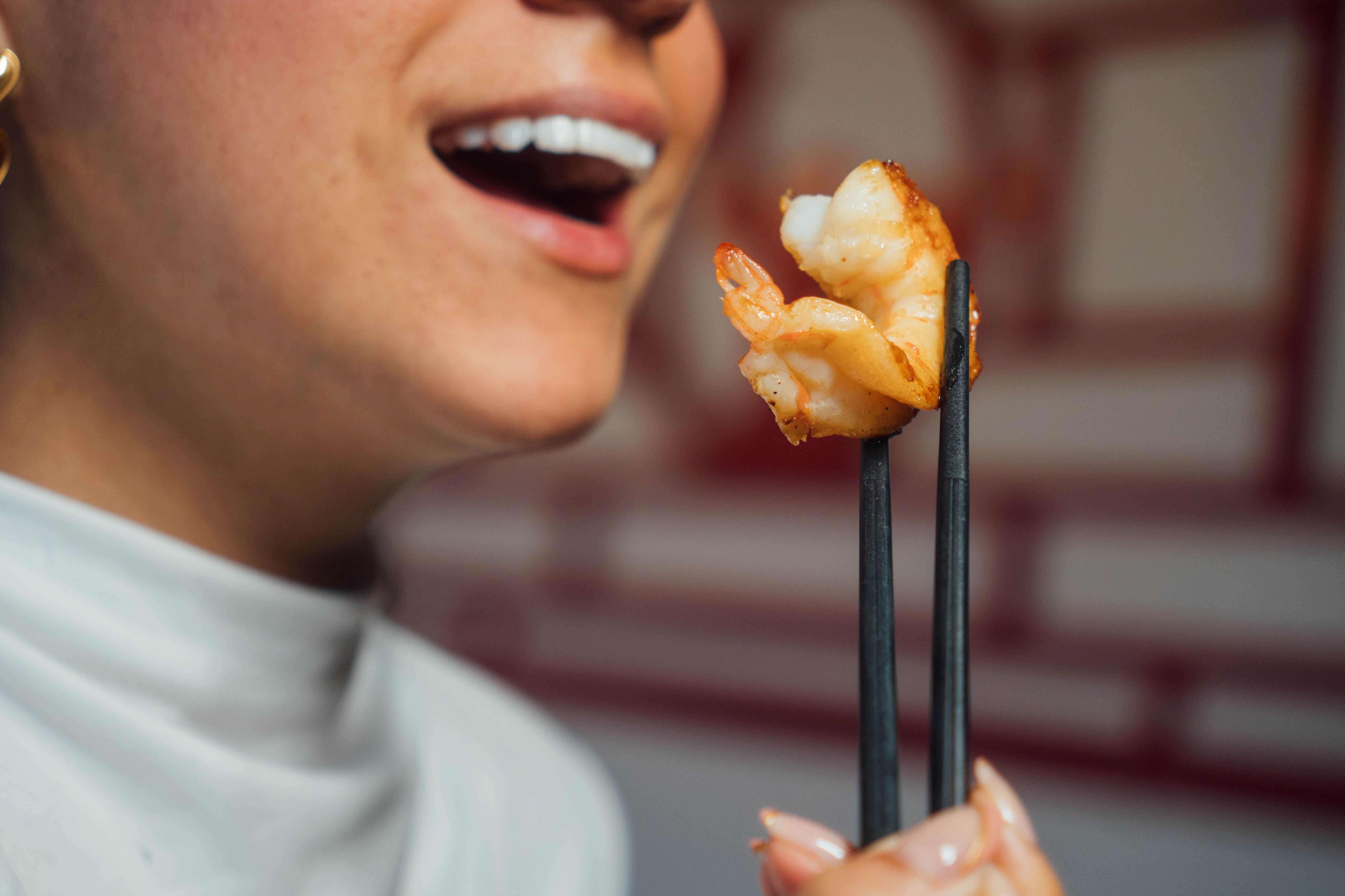Woman Enjoying Grilled Shrimp with Chopsticks · Free Stock Photo