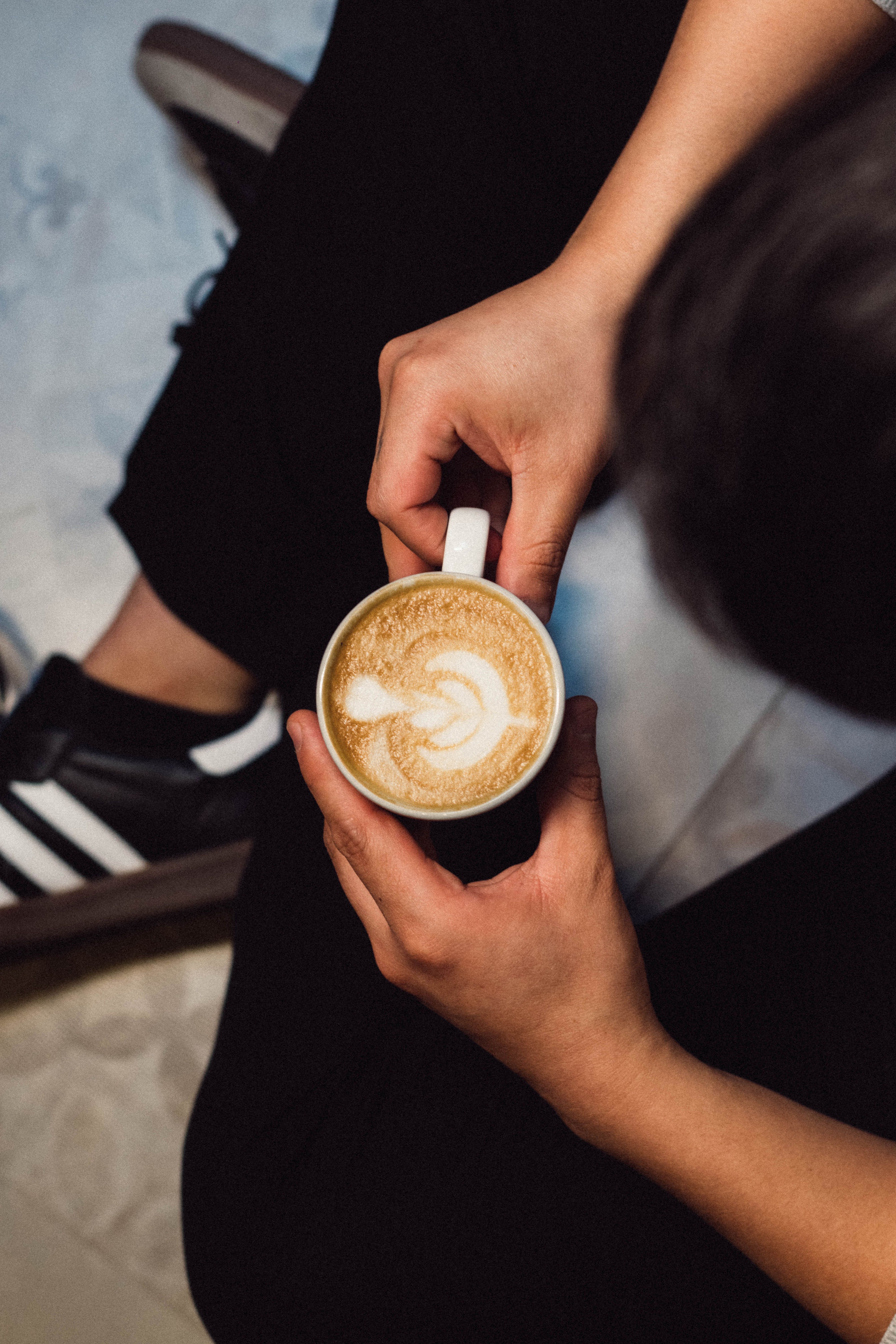 Top View of Person Holding Latte with Latte Art · Free Stock Photo