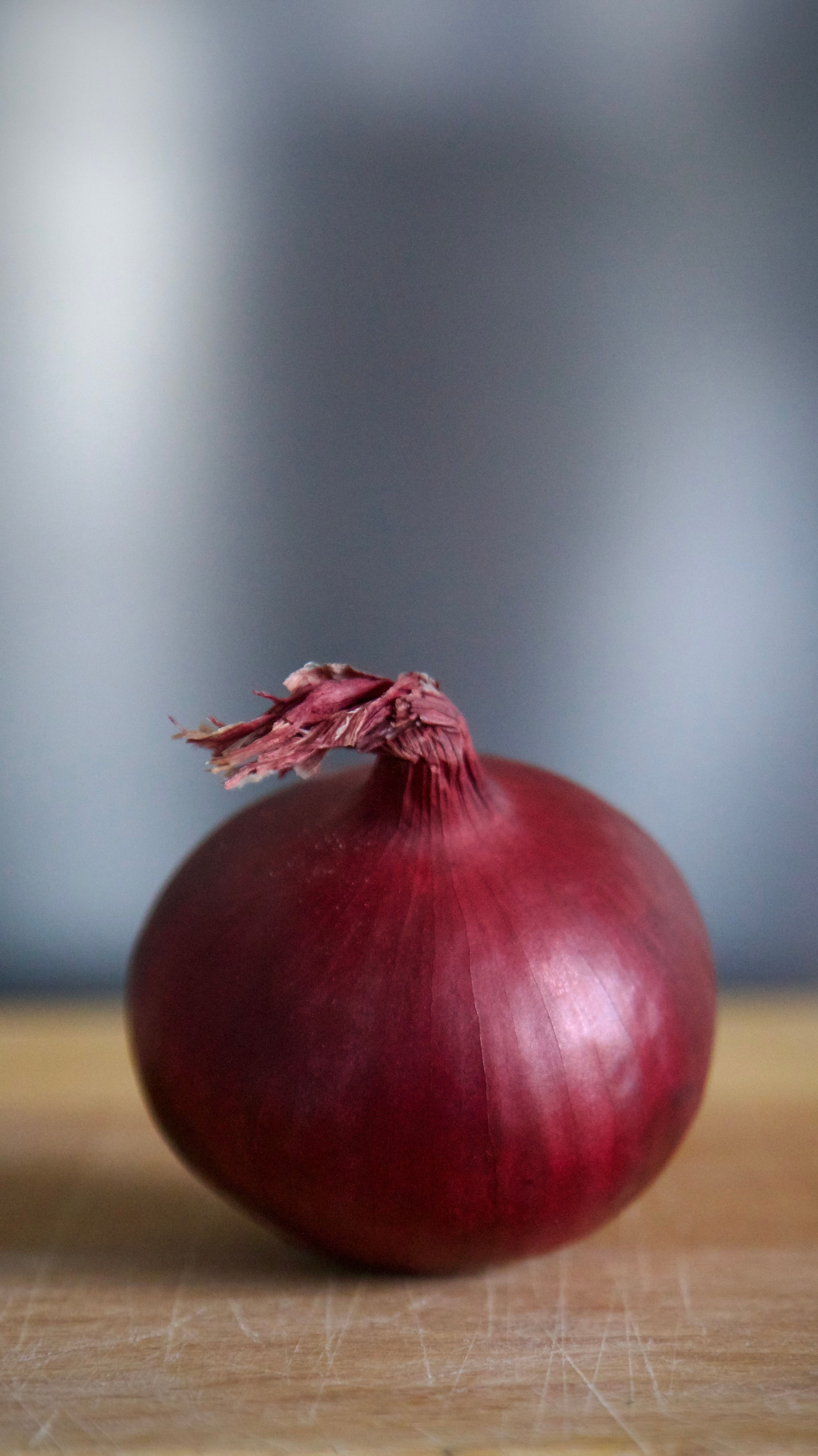 Close-Up of a Red Onion on Wooden Surface · Free Stock Photo