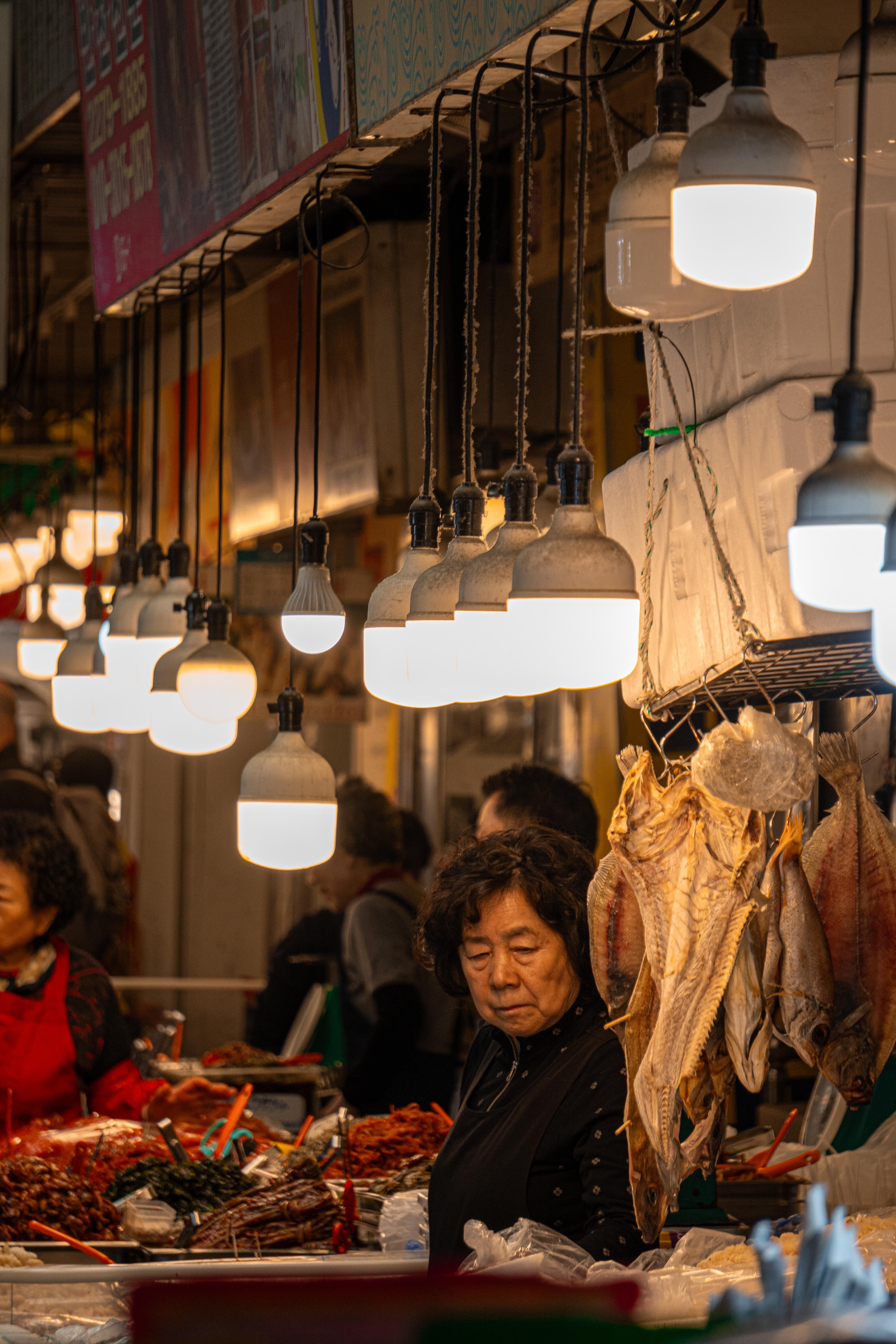 Bustling Asian Market with Hanging Lights and Dried Fish · Free Stock Photo
