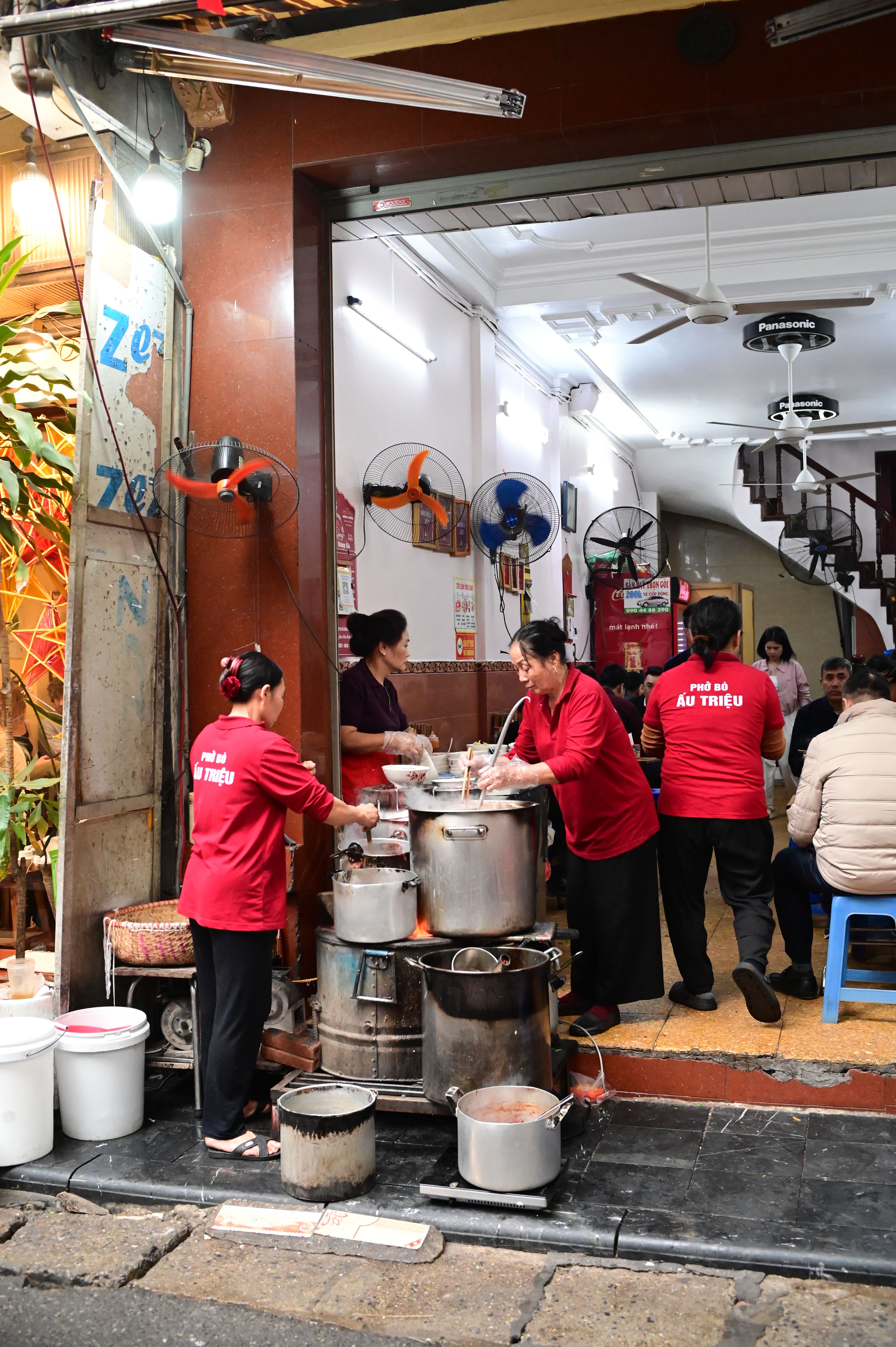 Street Food Stall with People Cooking in Hanoi · Free Stock Photo
