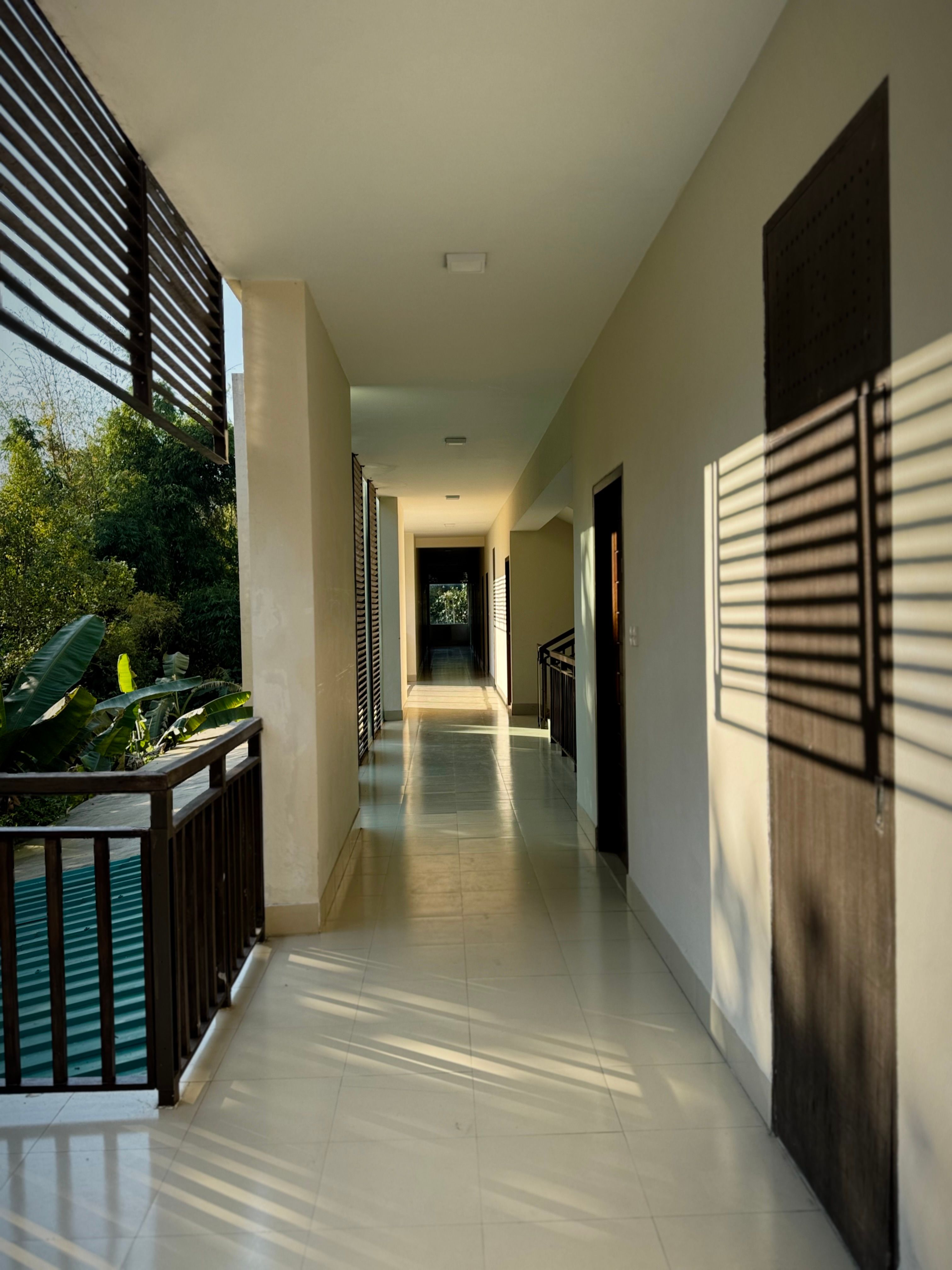 Sunlit Corridor with Wooden Louvers and Shadows · Free Stock Photo