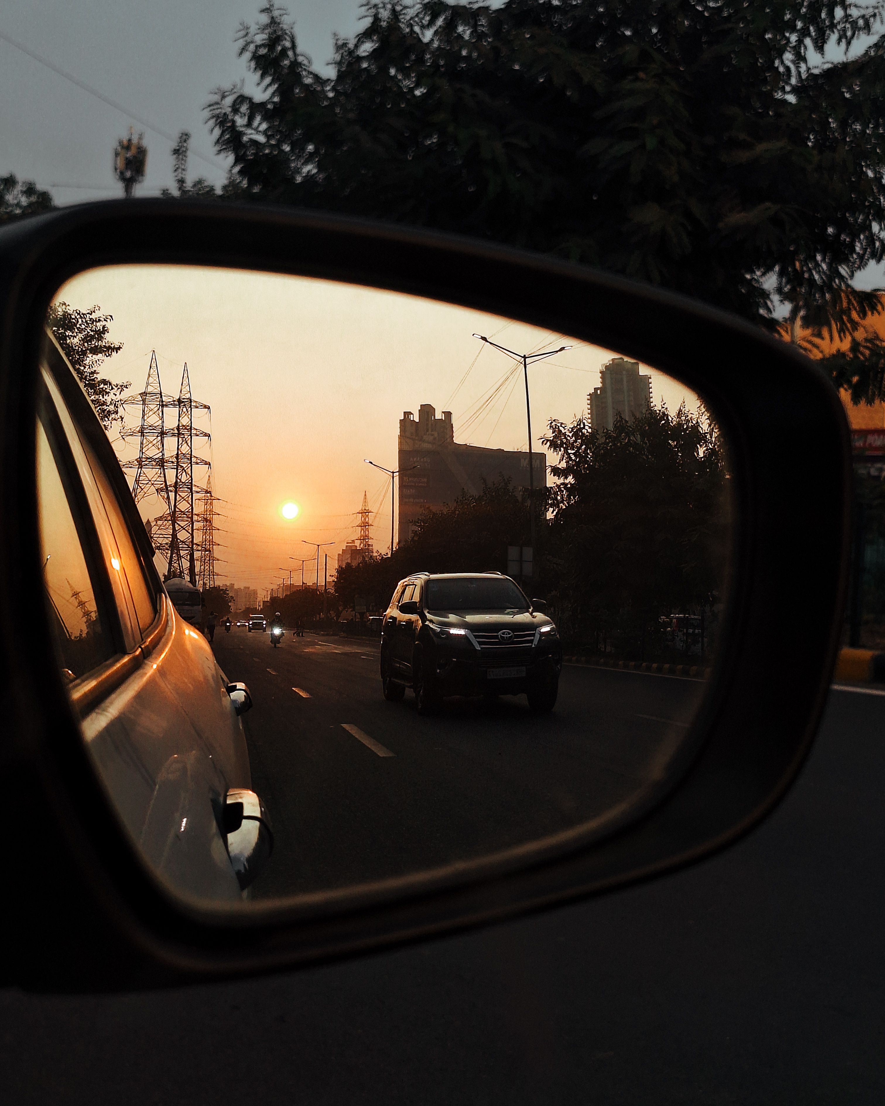 Sunset Reflection in Car Mirror on Urban Road · Free Stock Photo