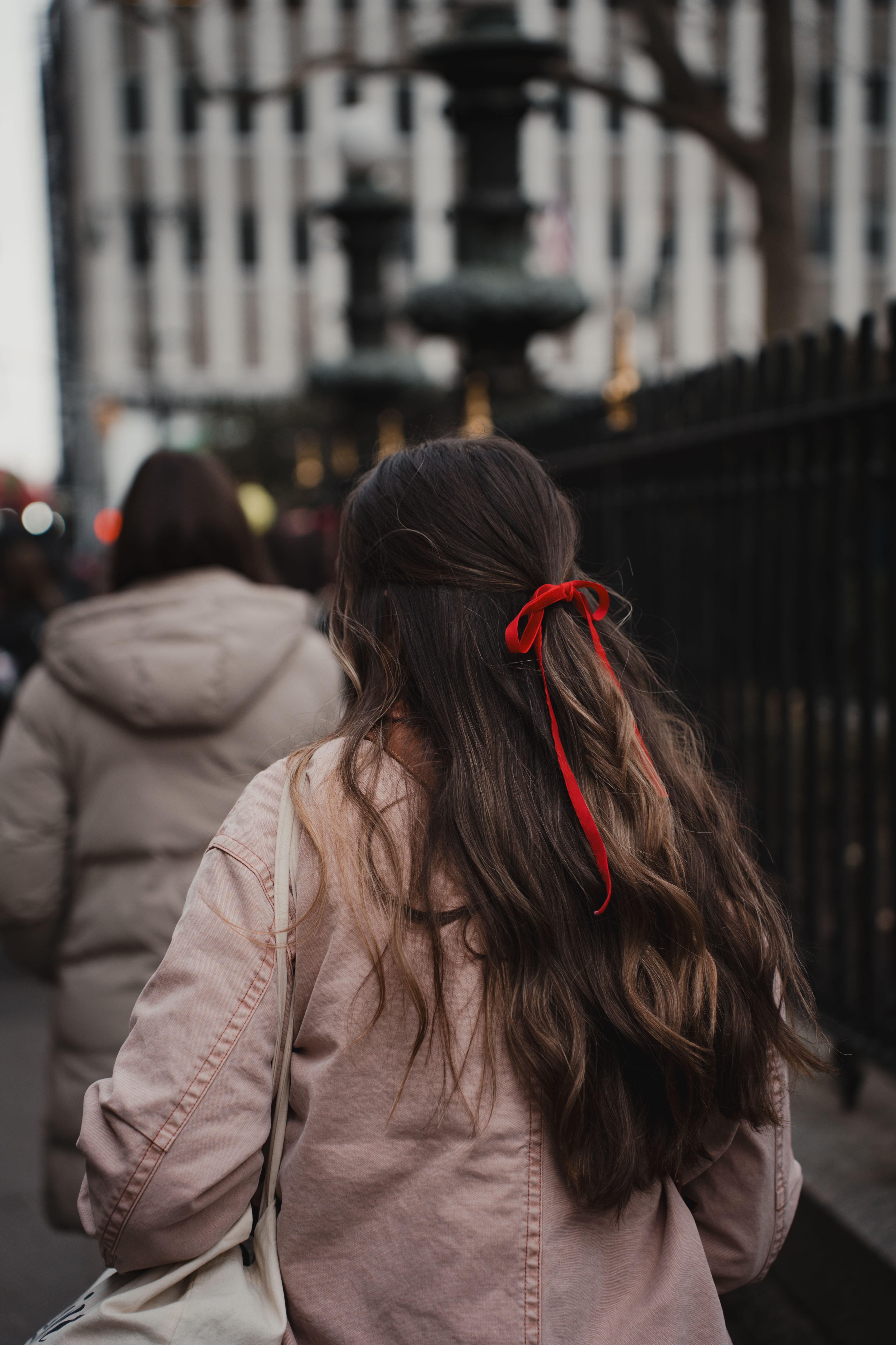 Woman in Red Ribbon Walking Through Urban Street · Free Stock Photo