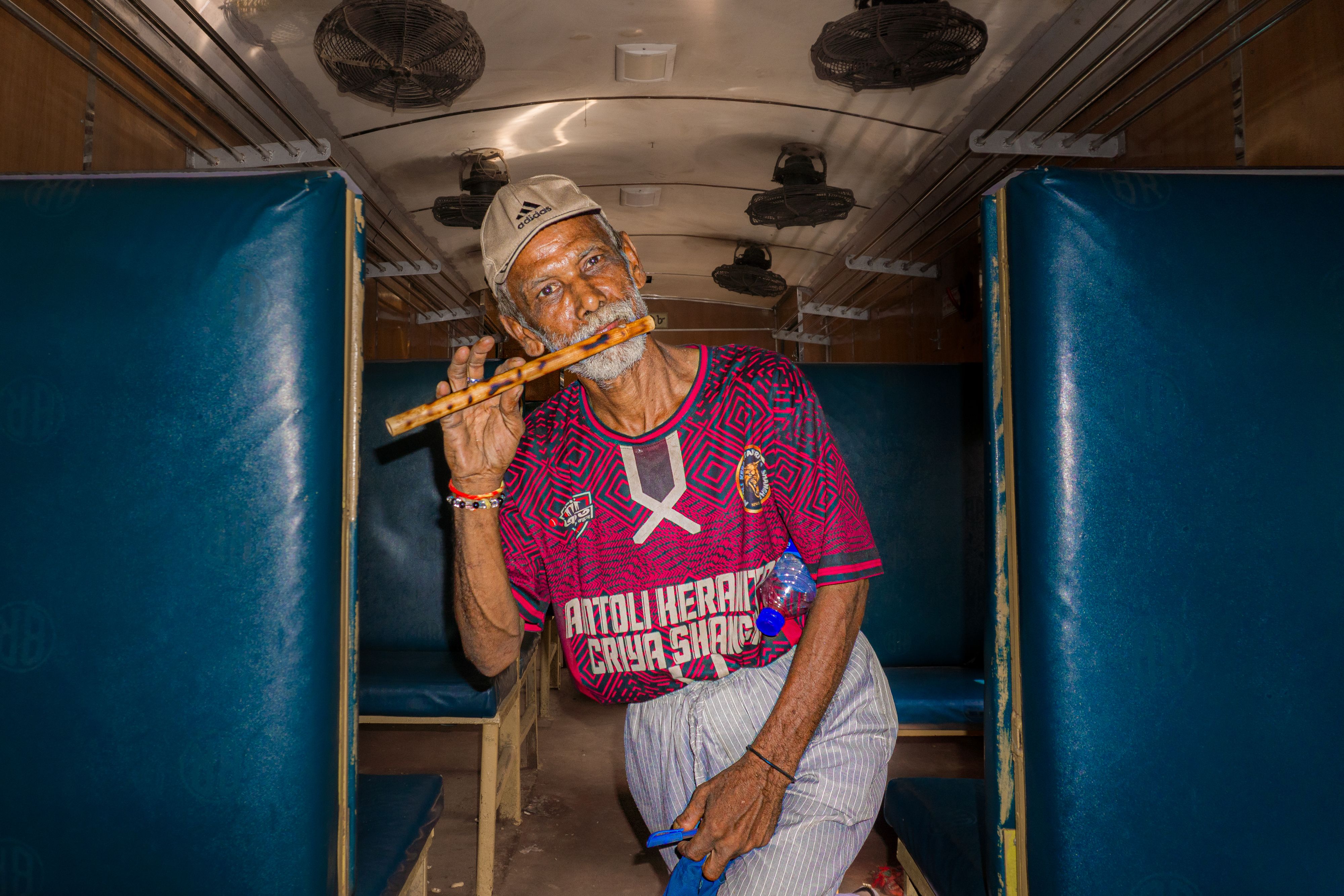 Man Playing Flute Inside Train Compartment · Free Stock Photo