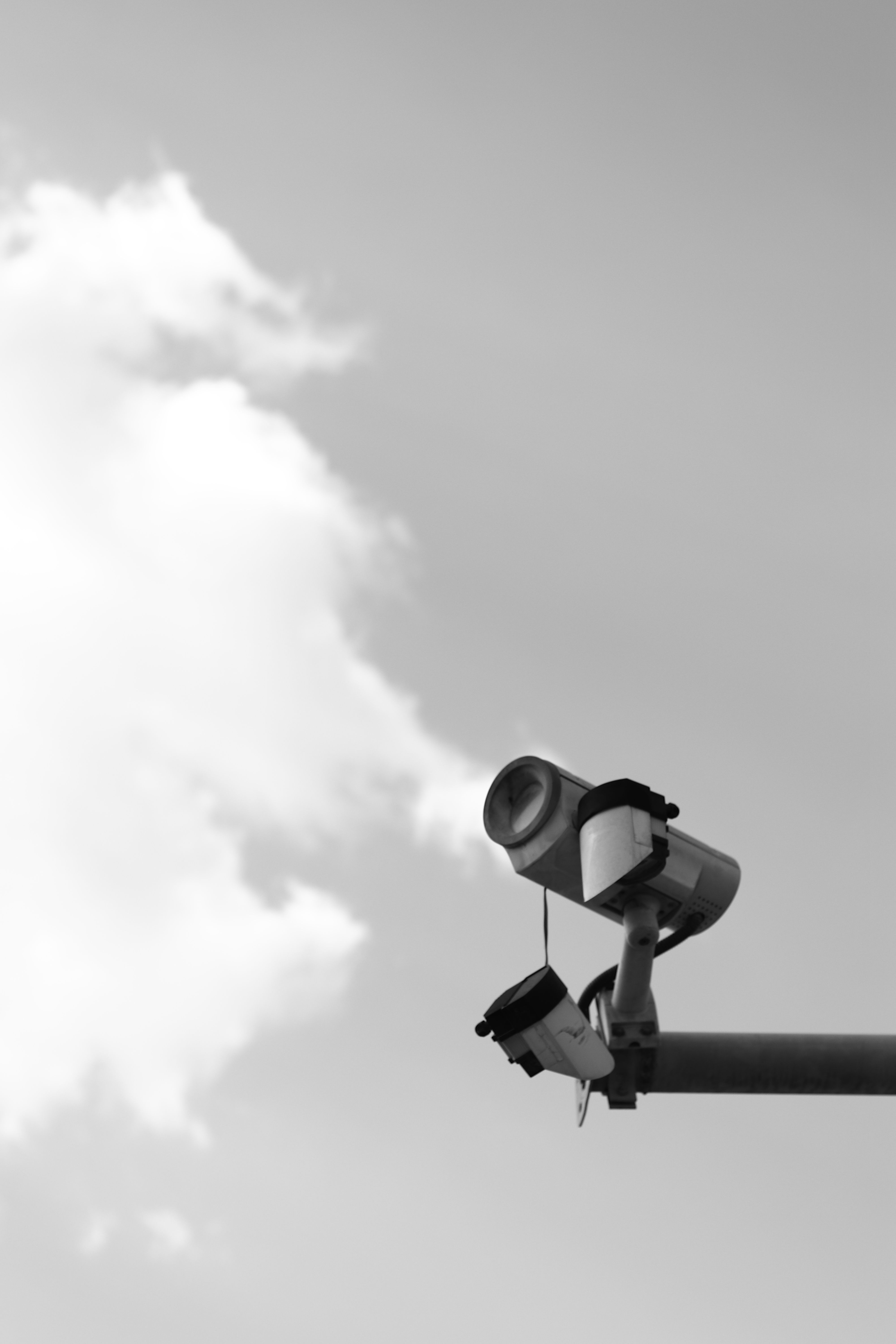Black and White Surveillance Camera Against Cloudy Sky · Free Stock Photo