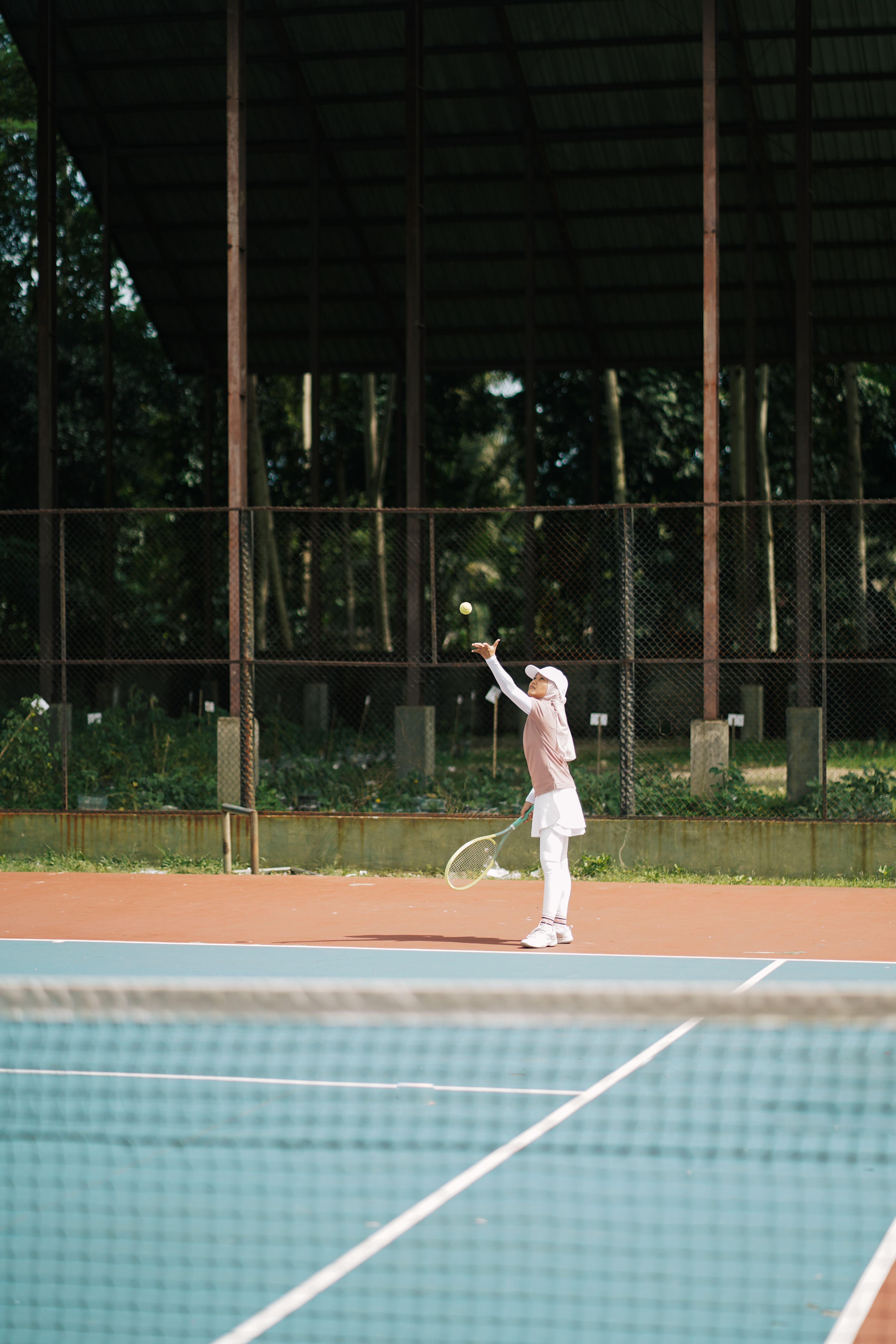 Man Playing Tennis on Court in Tropical Landscape · Free Stock Photo