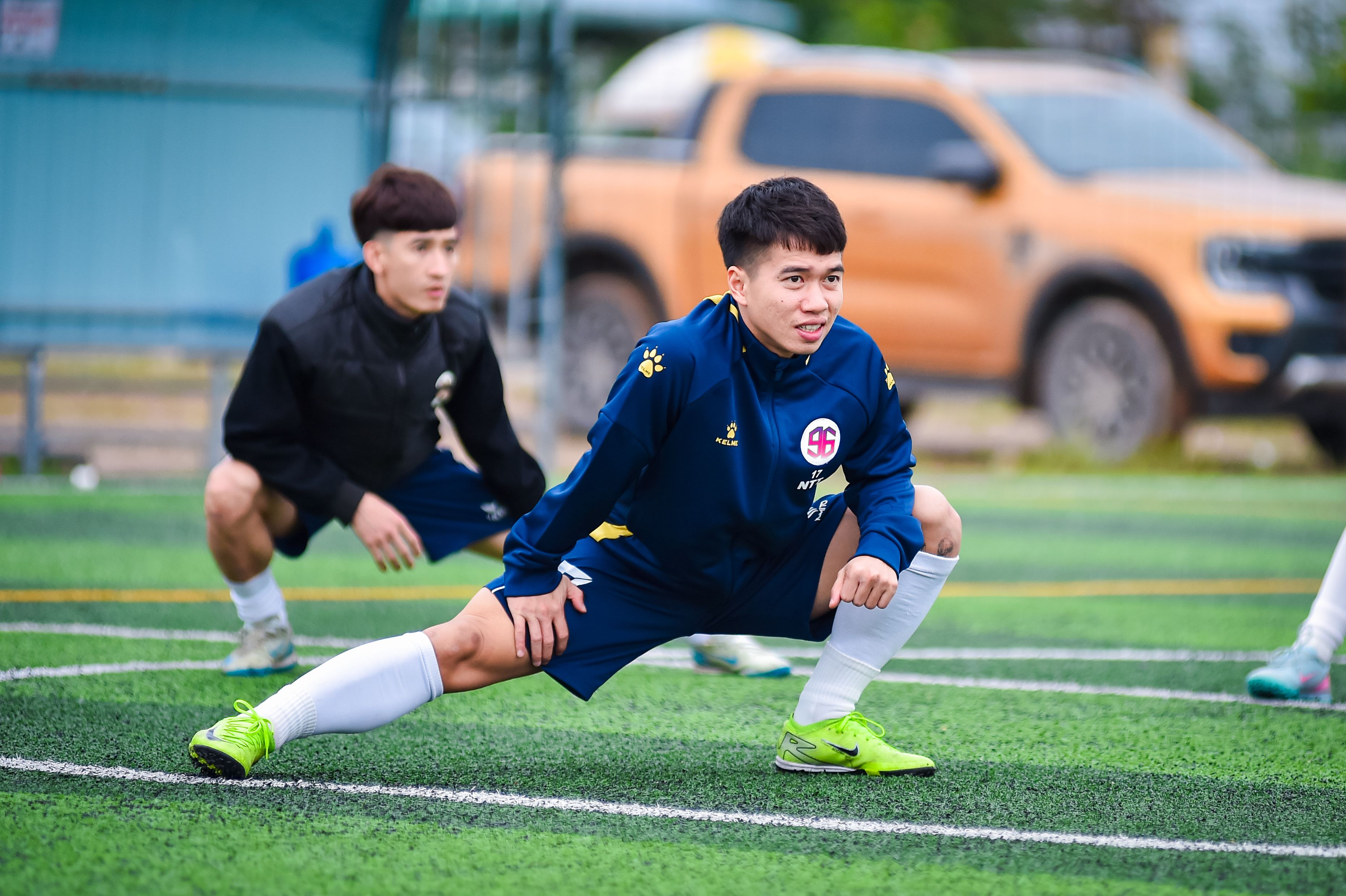 Young Athletes Stretching on Football Field in Hanoi · Free Stock Photo