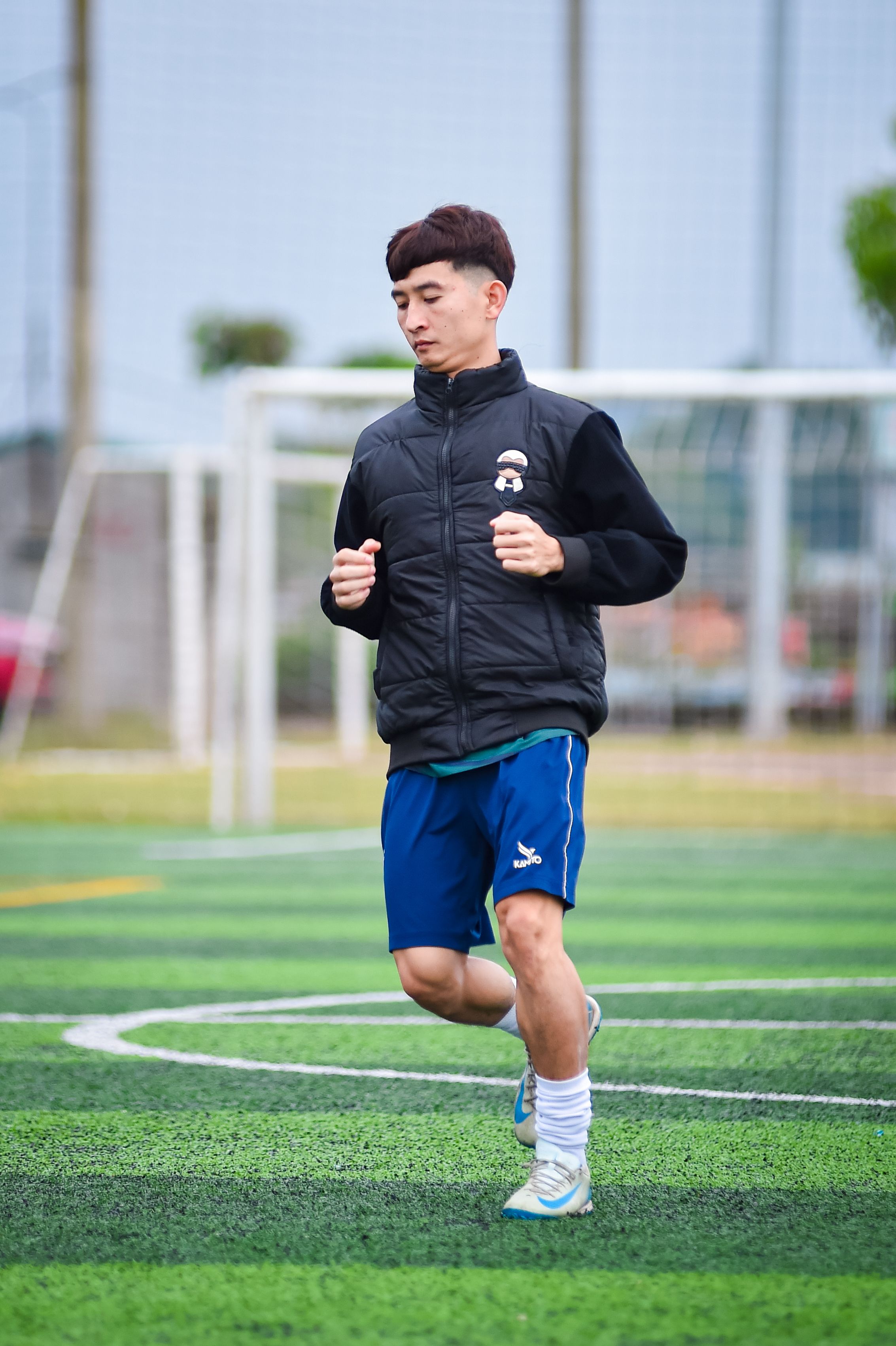 Young Football Player Jogging on Artificial Turf · Free Stock Photo