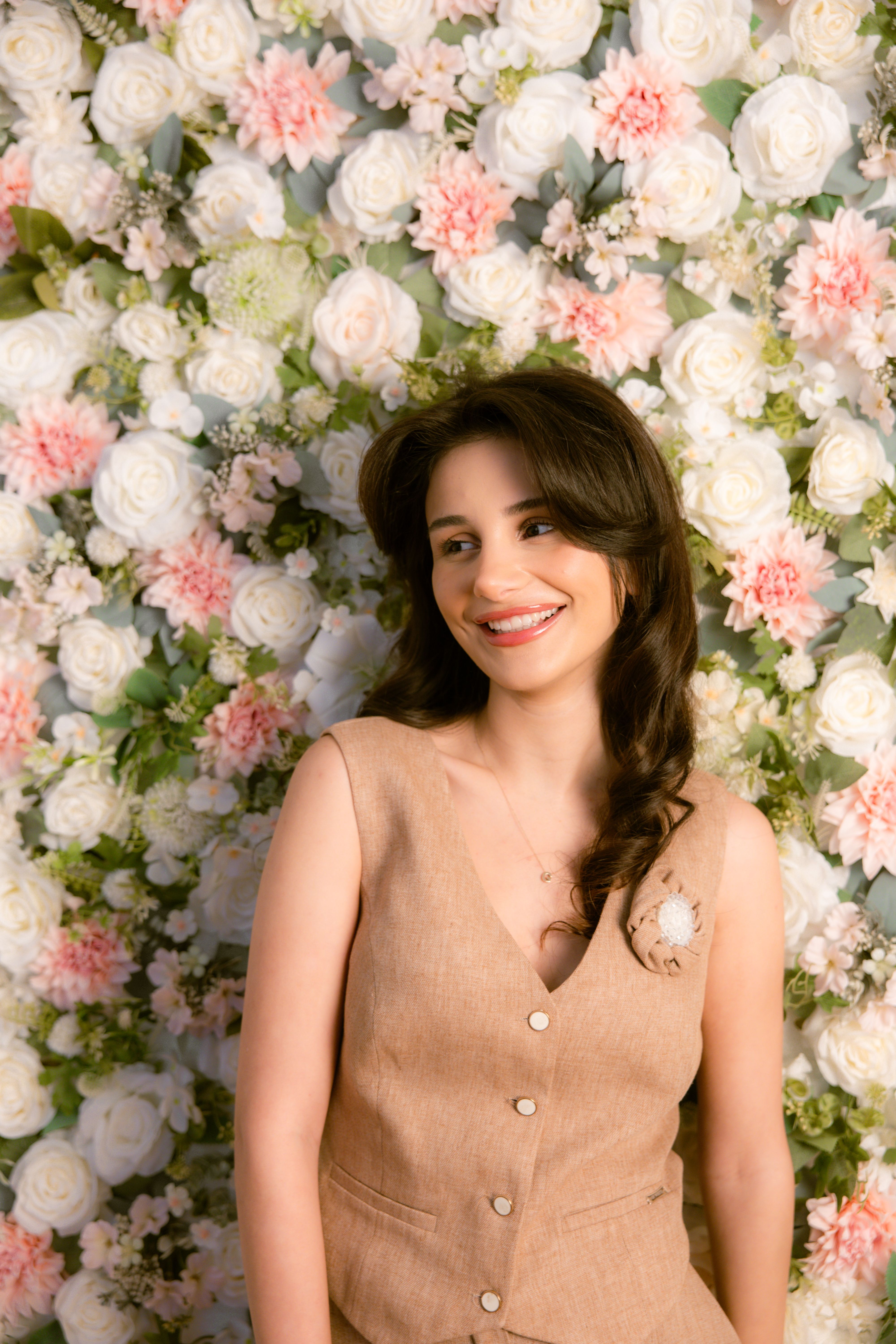 Smiling Woman in Front of Floral Backdrop · Free Stock Photo