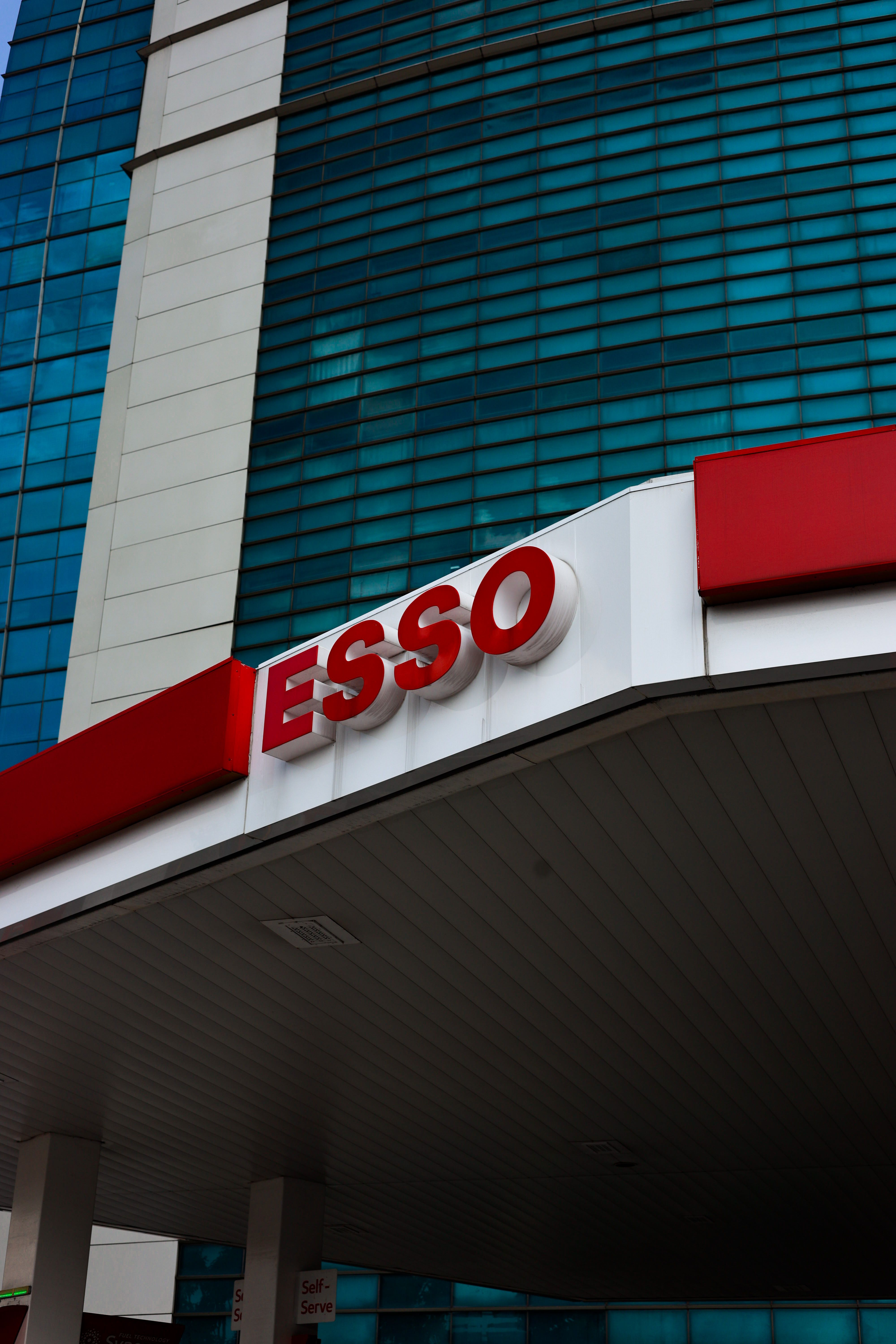 Esso Gas Station in Front of Modern Building · Free Stock Photo
