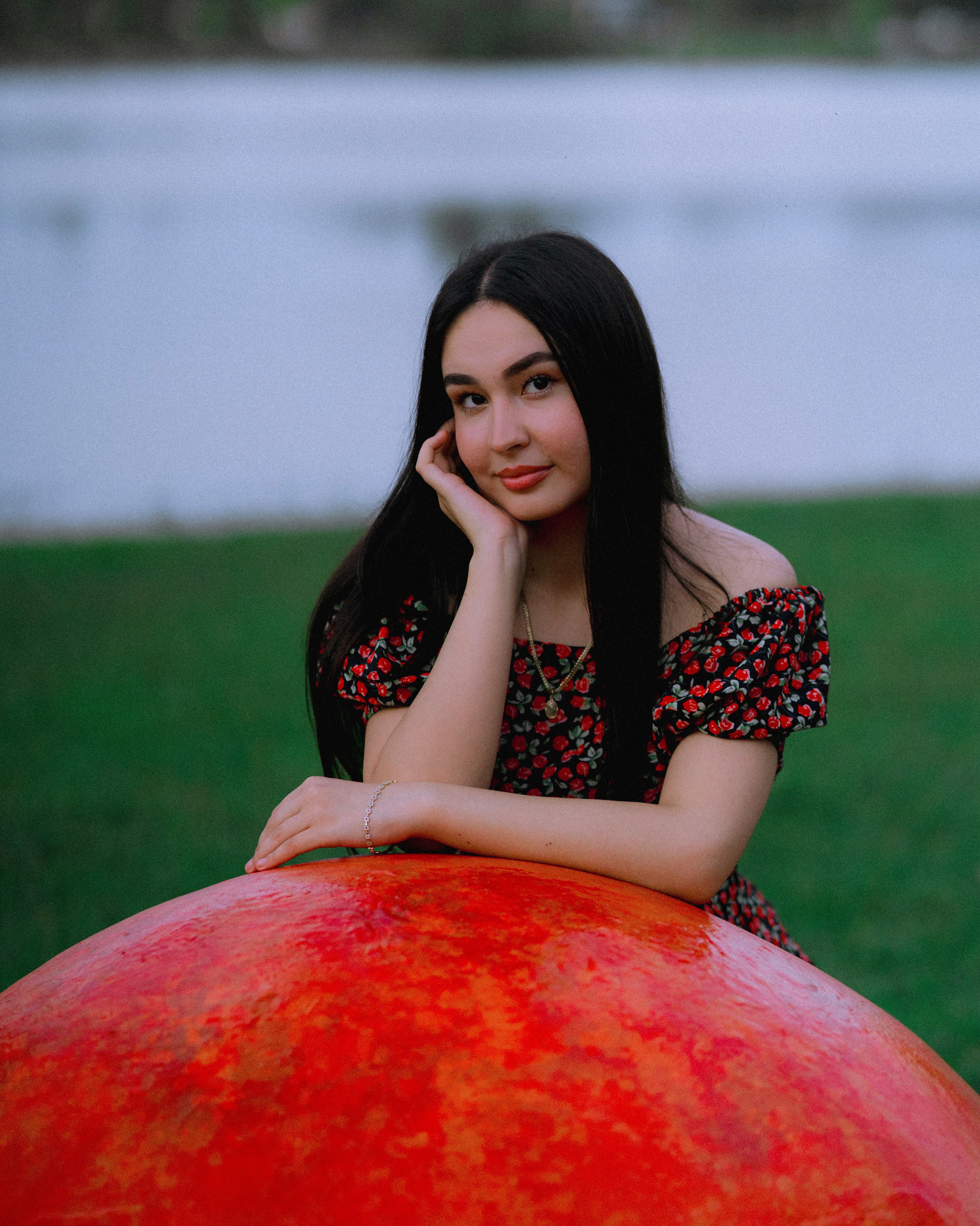 Young Woman Posing Outdoors with Red Sphere · Free Stock Photo