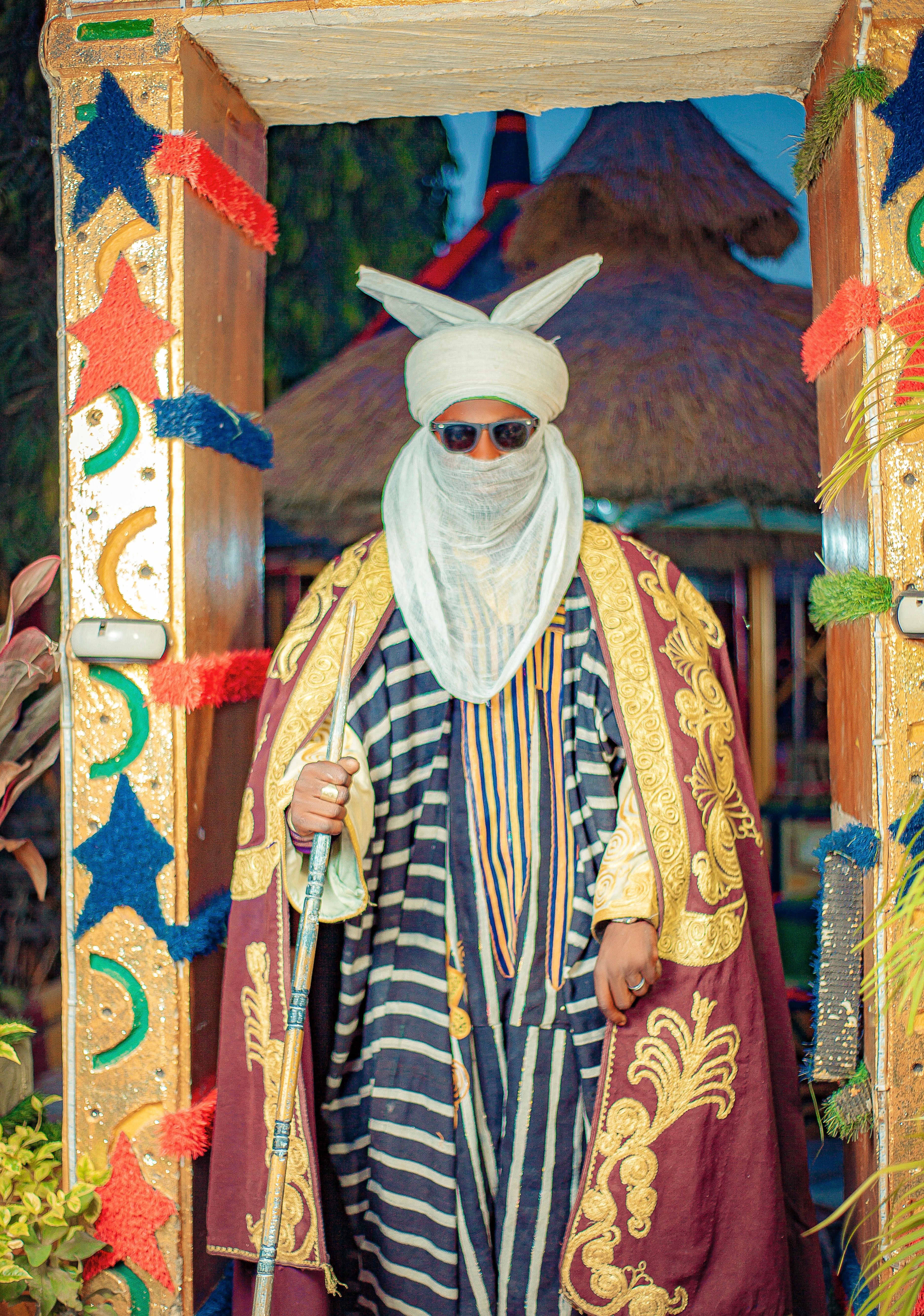 Traditional African Attire with Ornate Doorway · Free Stock Photo