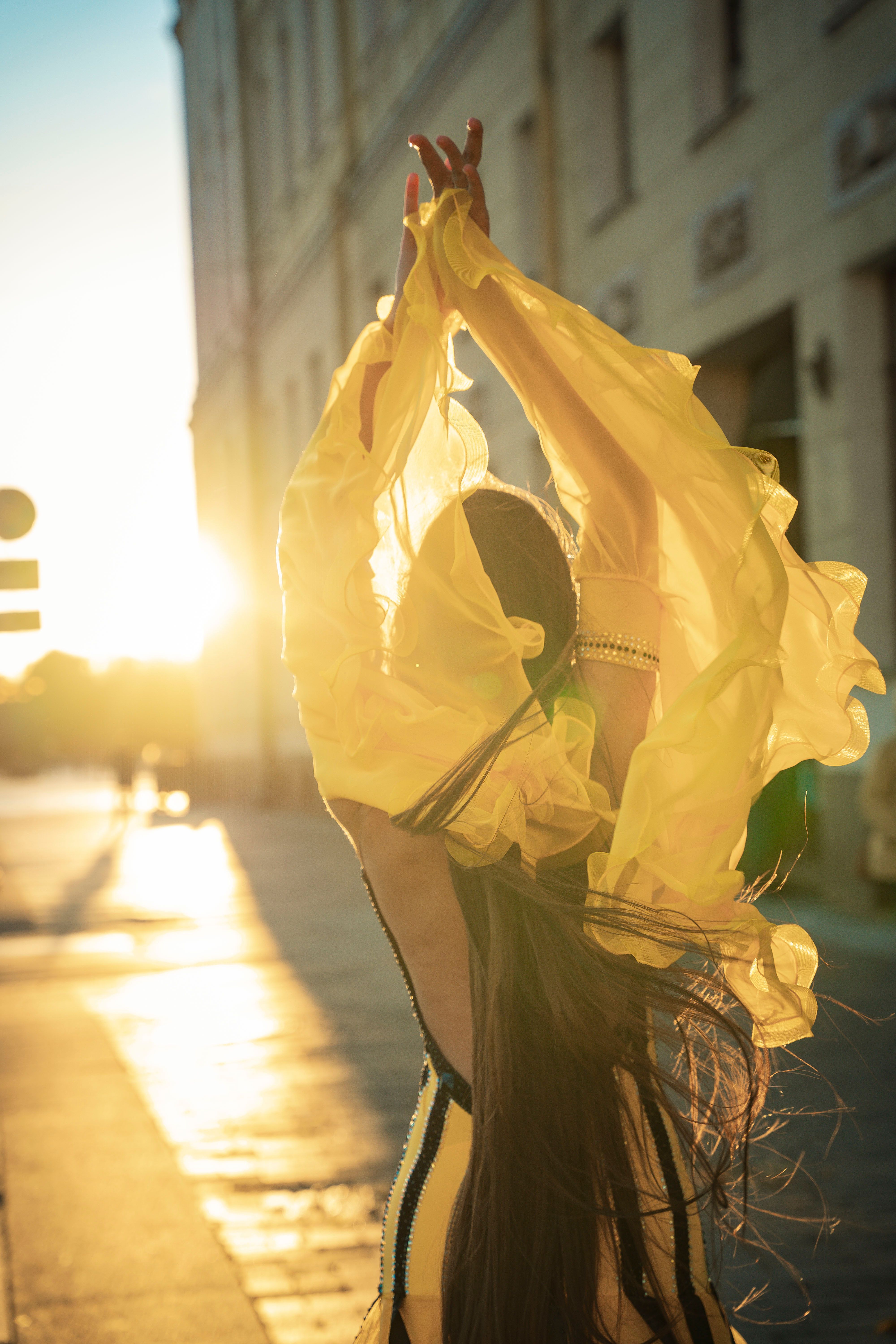 Elegant Woman Dancing at Sunset in City Street · Free Stock Photo