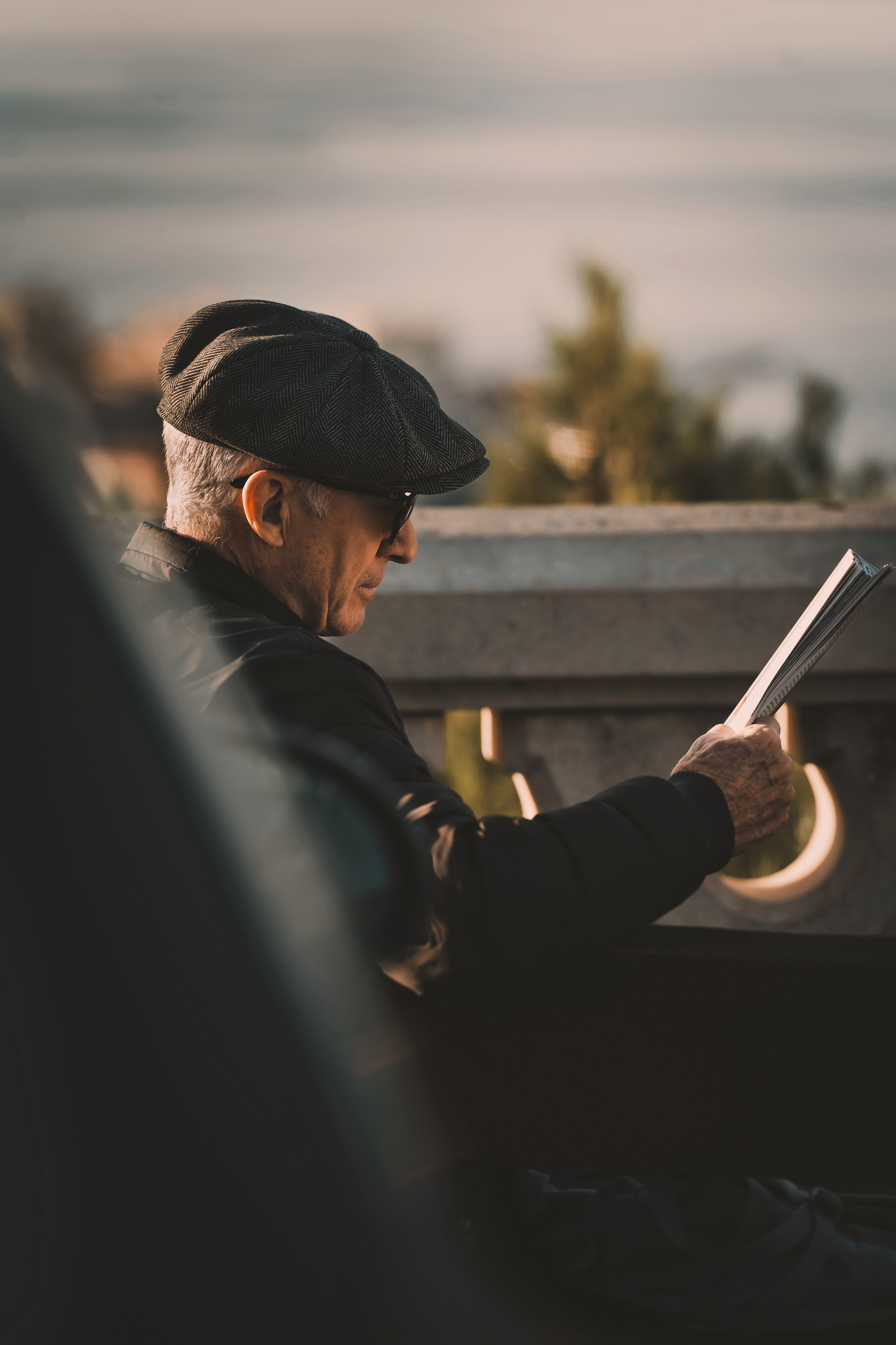 Senior Man Reading Outdoors in Autumn Sunlight · Free Stock Photo
