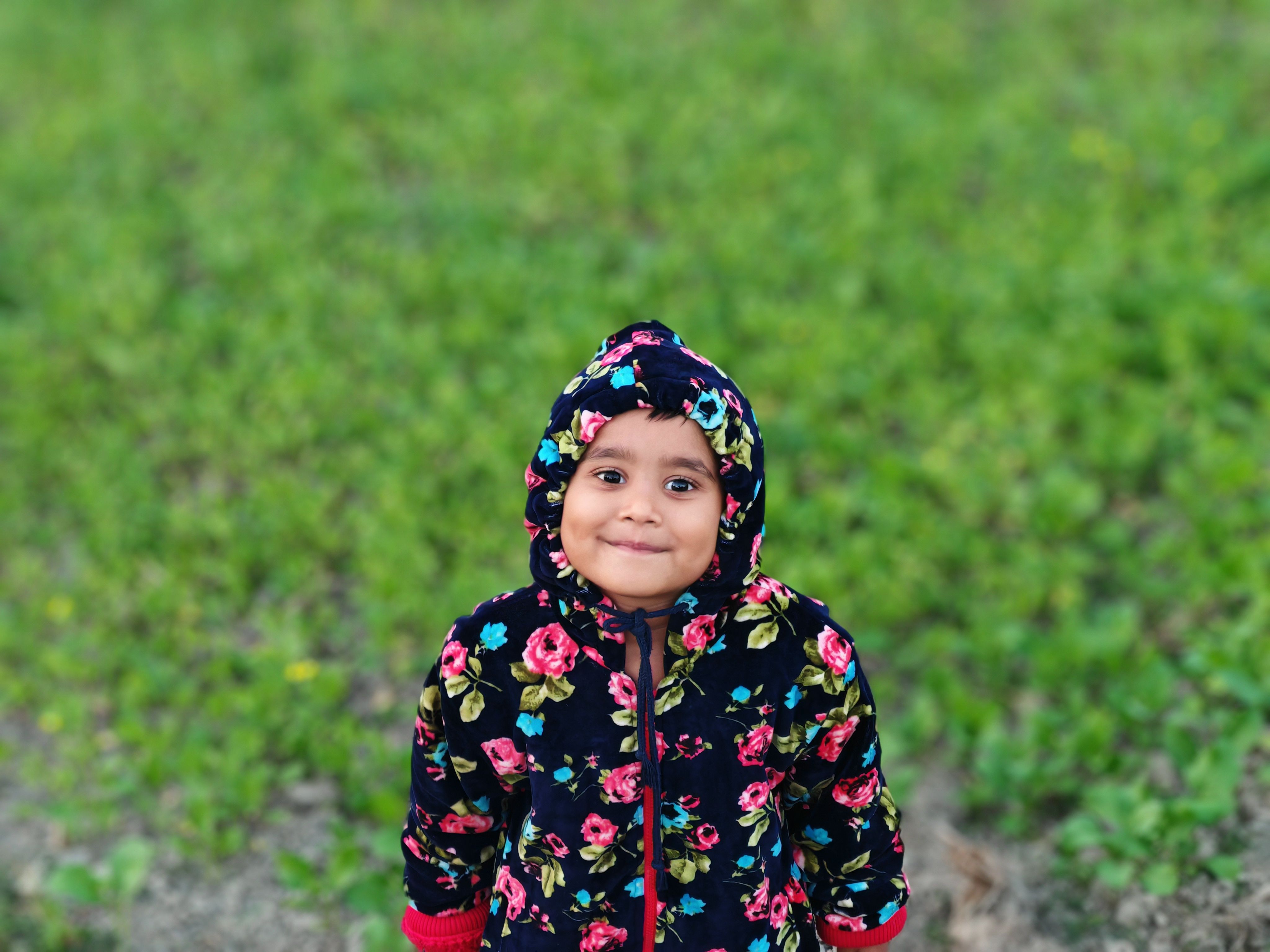 Smiling Child in Floral Jacket Outdoors · Free Stock Photo
