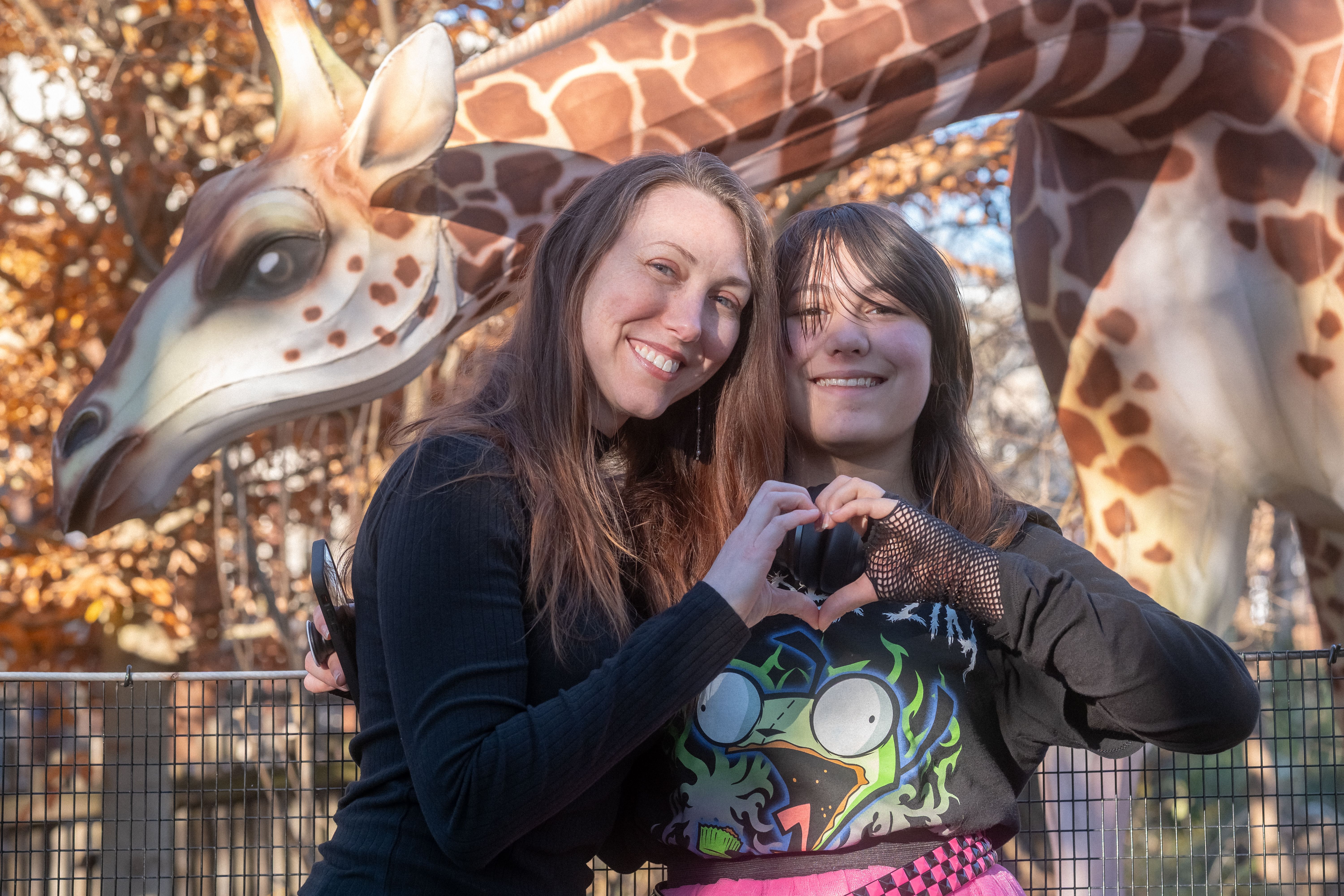 Smiling Friends with Giraffe Sculpture at Zoo · Free Stock Photo