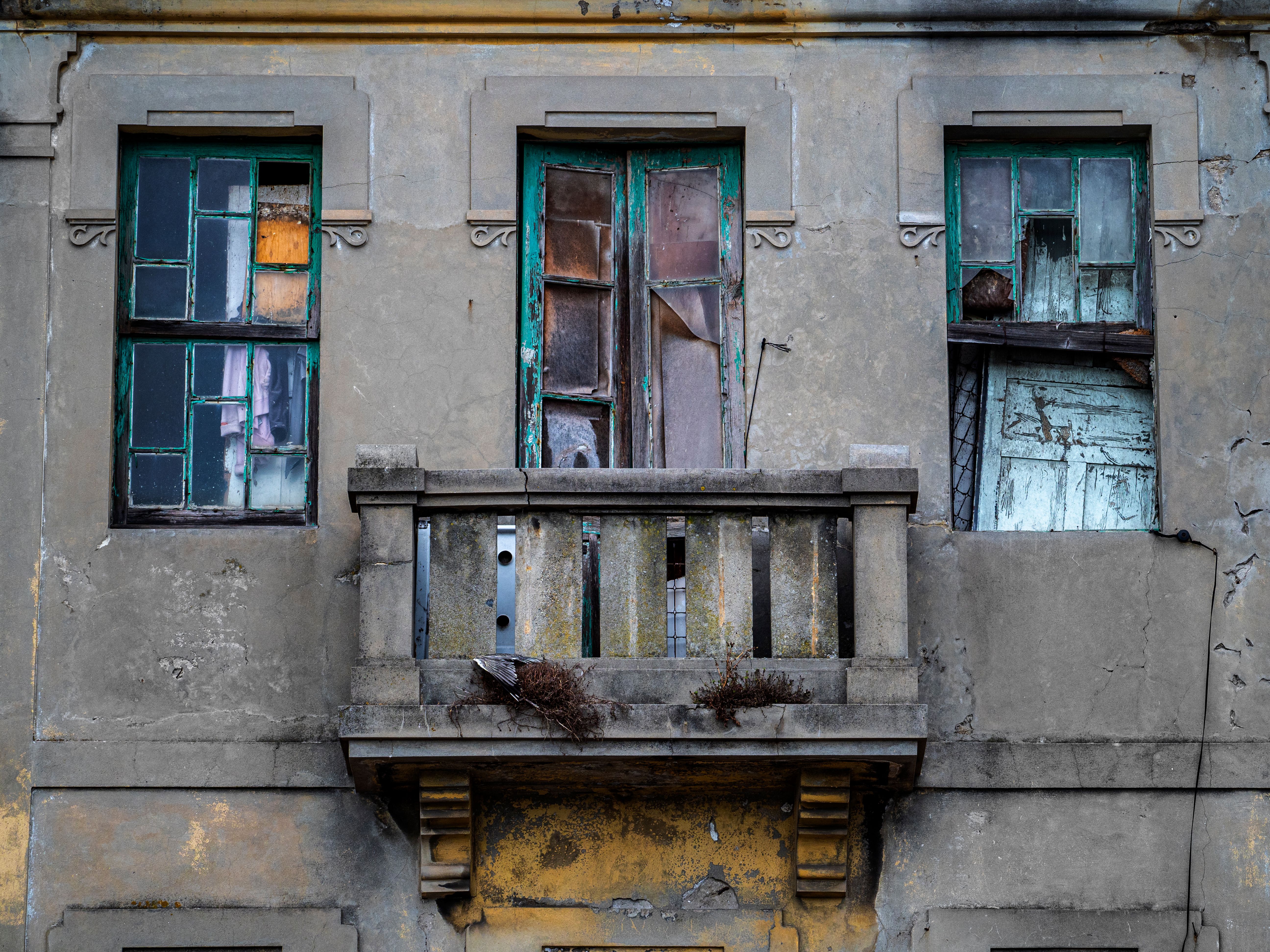 Aged Building Façade with Weathered Windows · Free Stock Photo