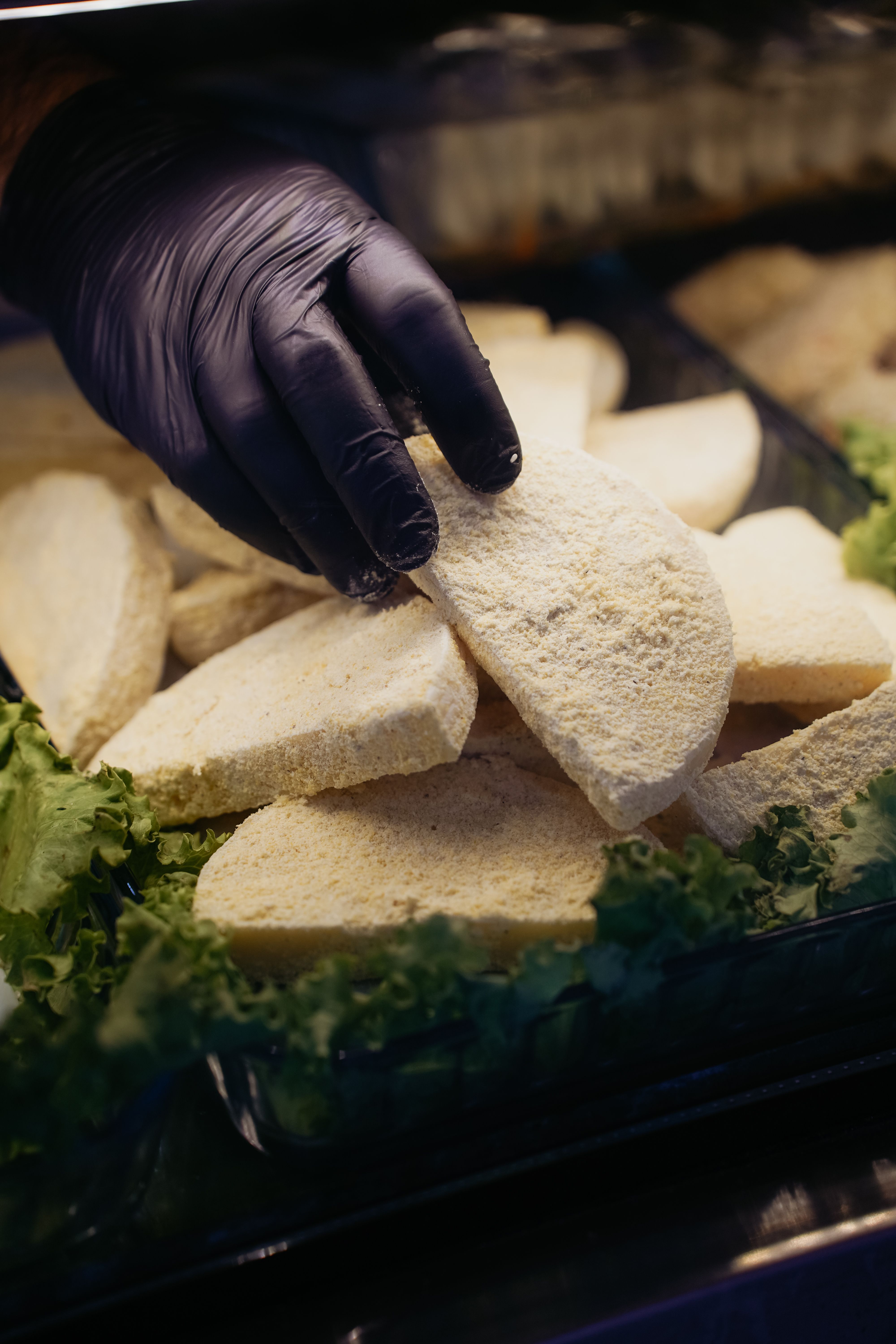Gloved Hand Handling Breaded Cheese Slices · Free Stock Photo