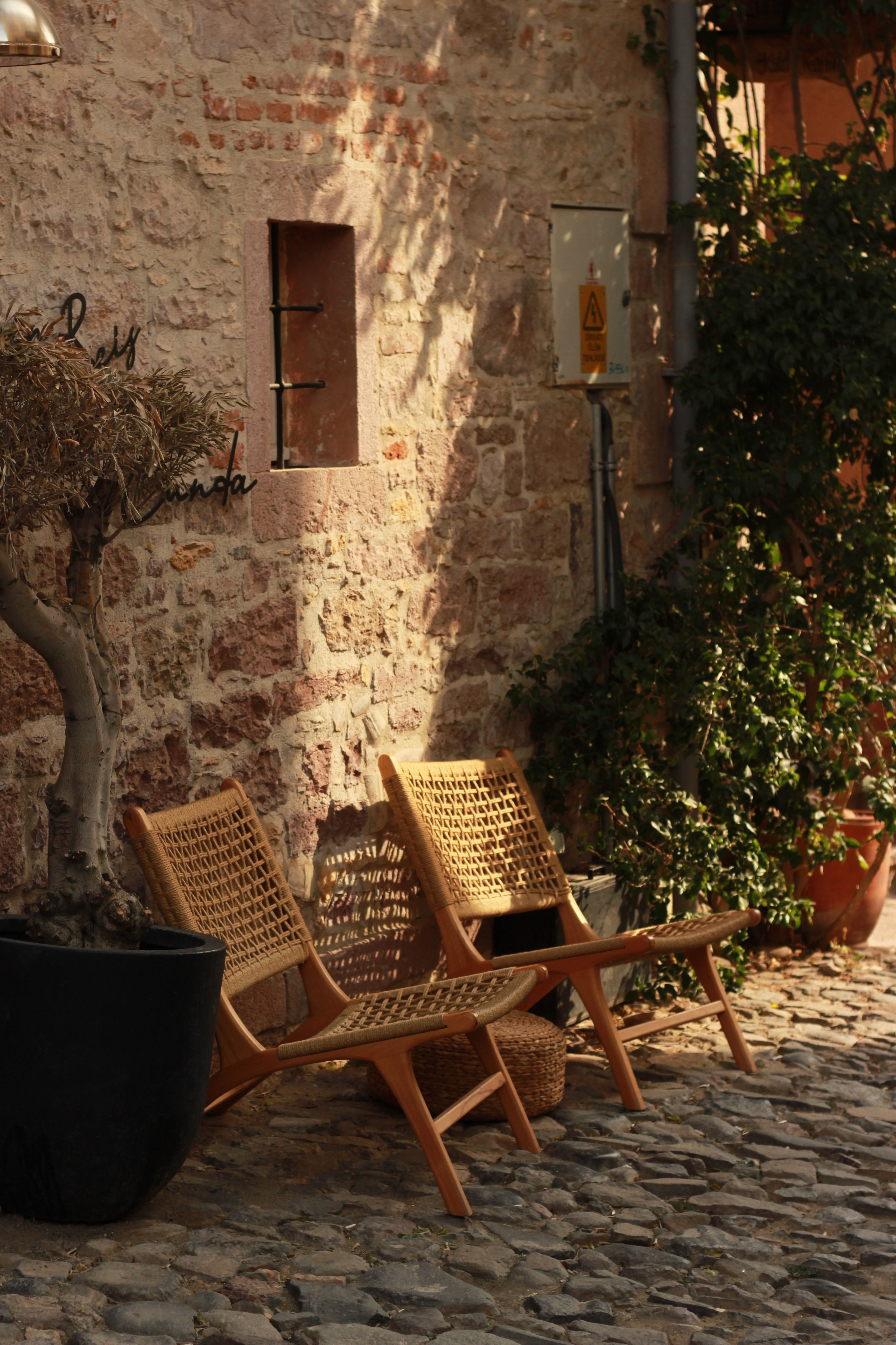 Cozy Outdoor Seating Against Rustic Brick Wall · Free Stock Photo