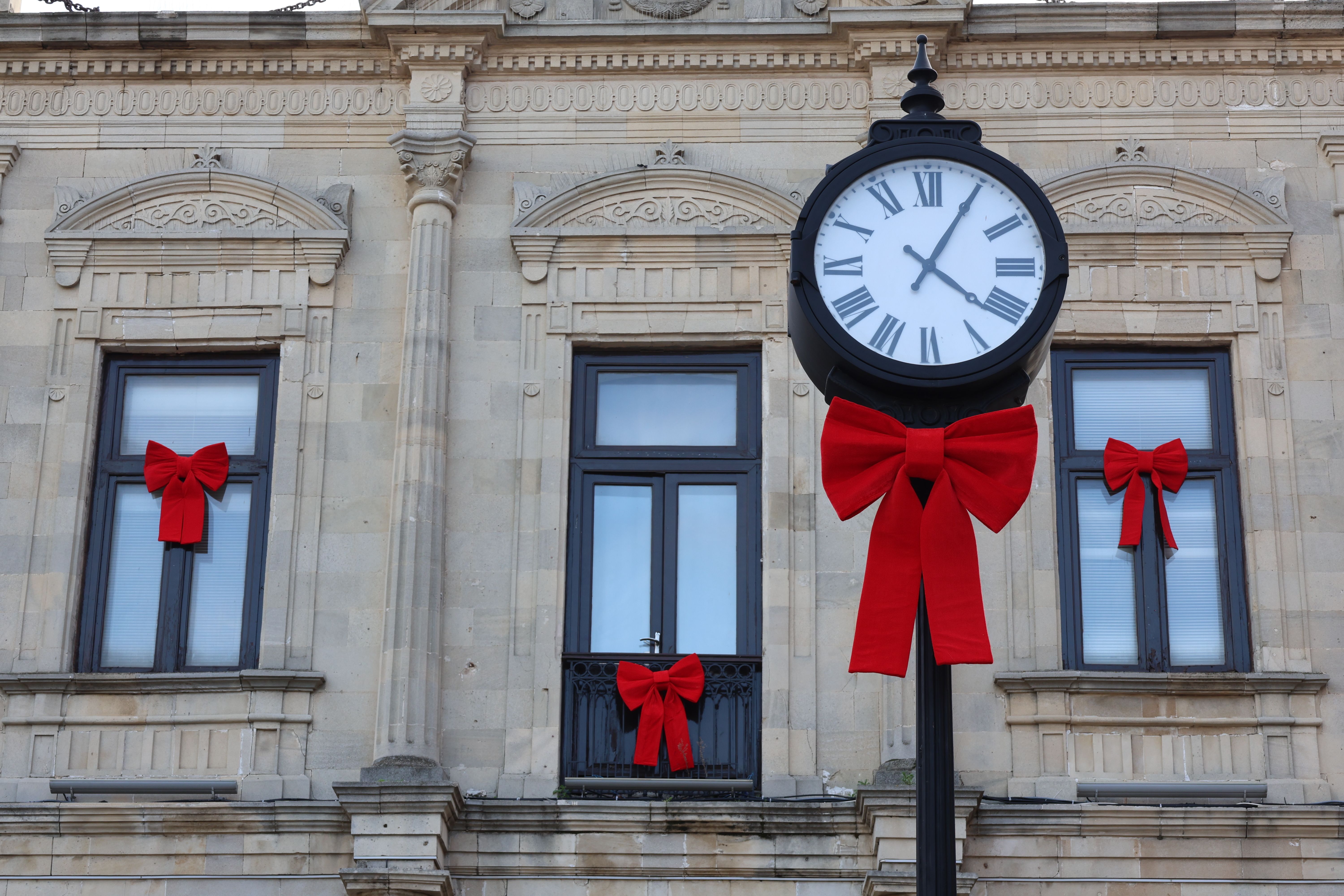 Vintage Building with Decorated Clock and Red Ribbons · Free Stock Photo