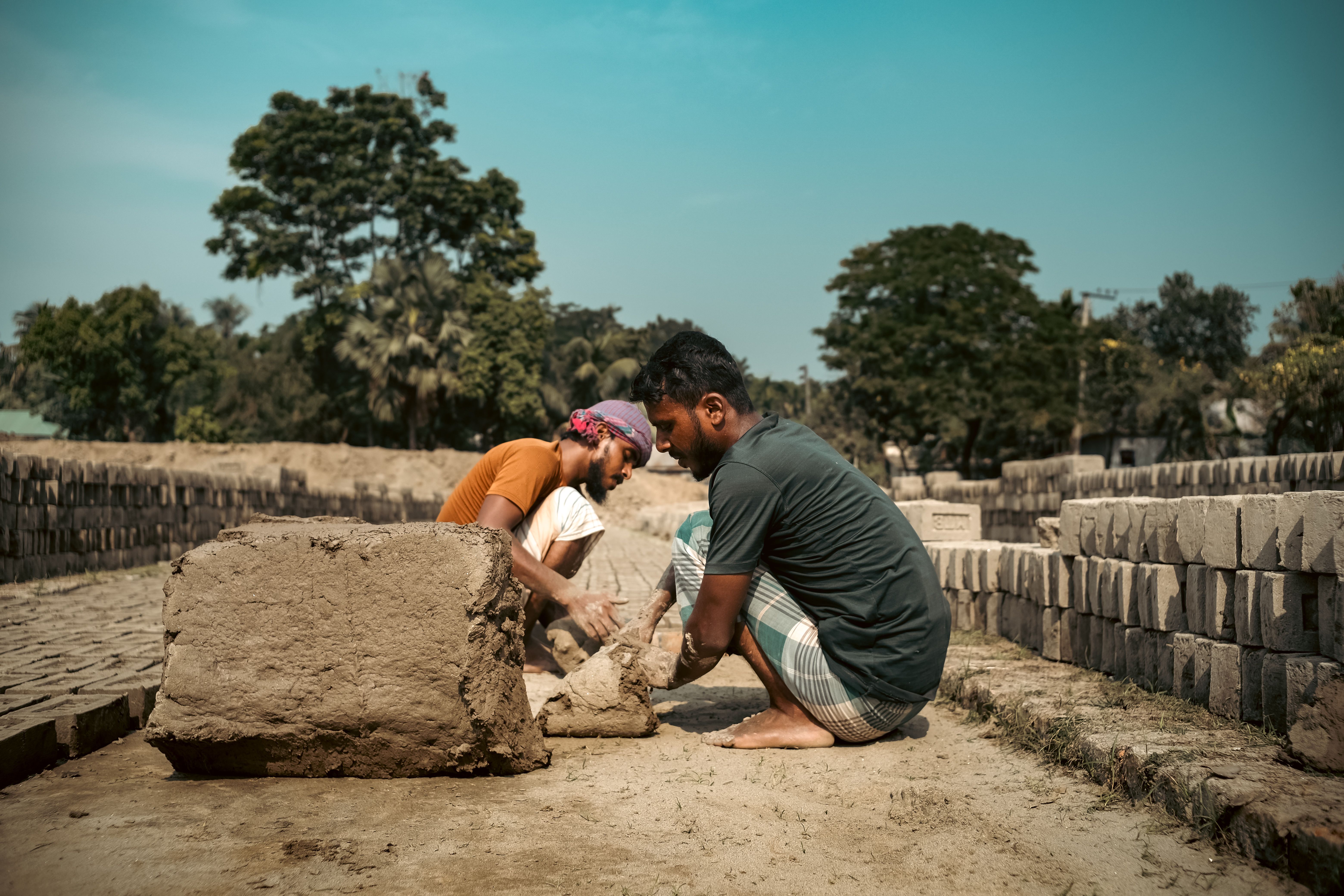 Workers Building Bricks in Outdoor Setting · Free Stock Photo