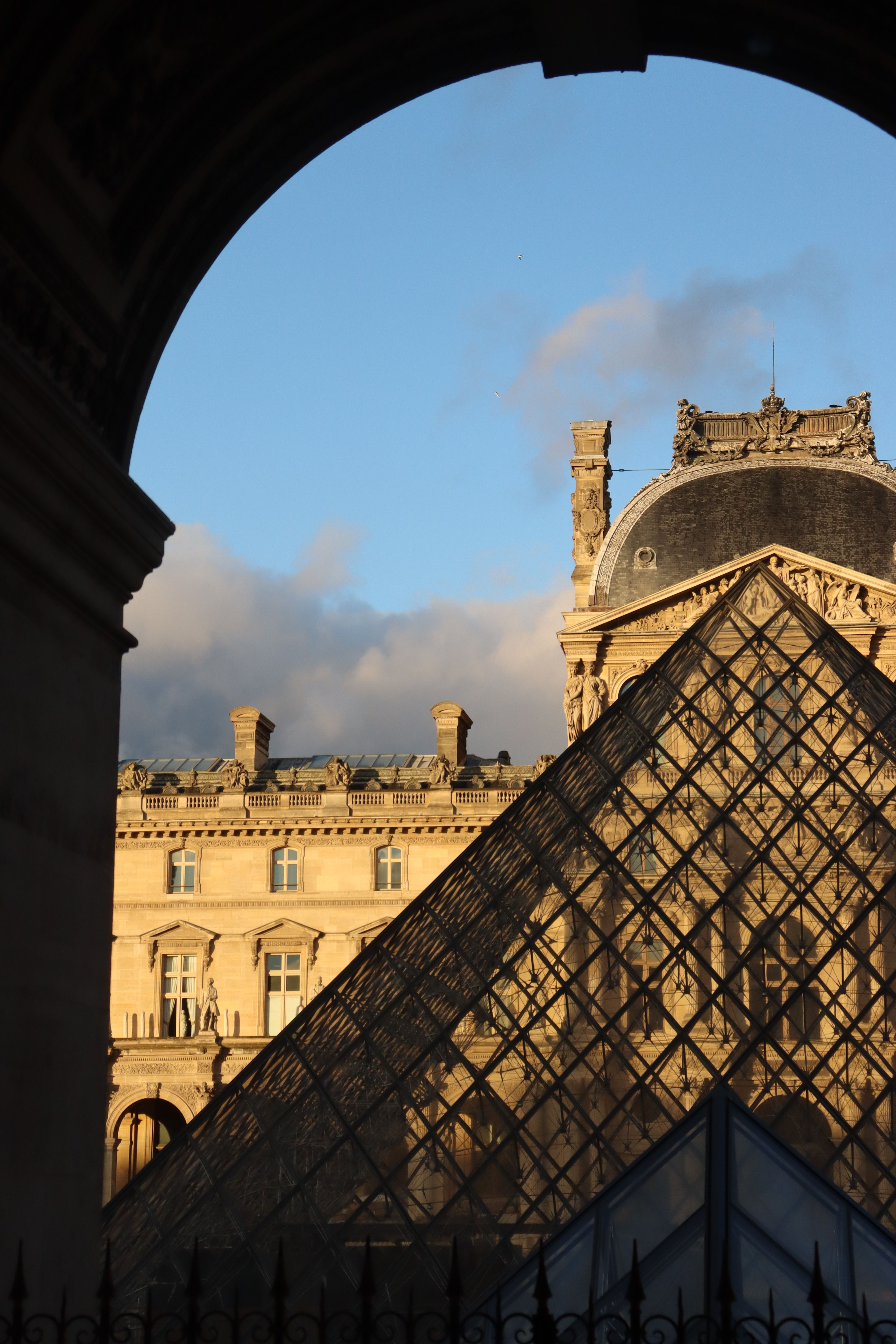 Louvre Pyramid Framed by Arched Window · Free Stock Photo