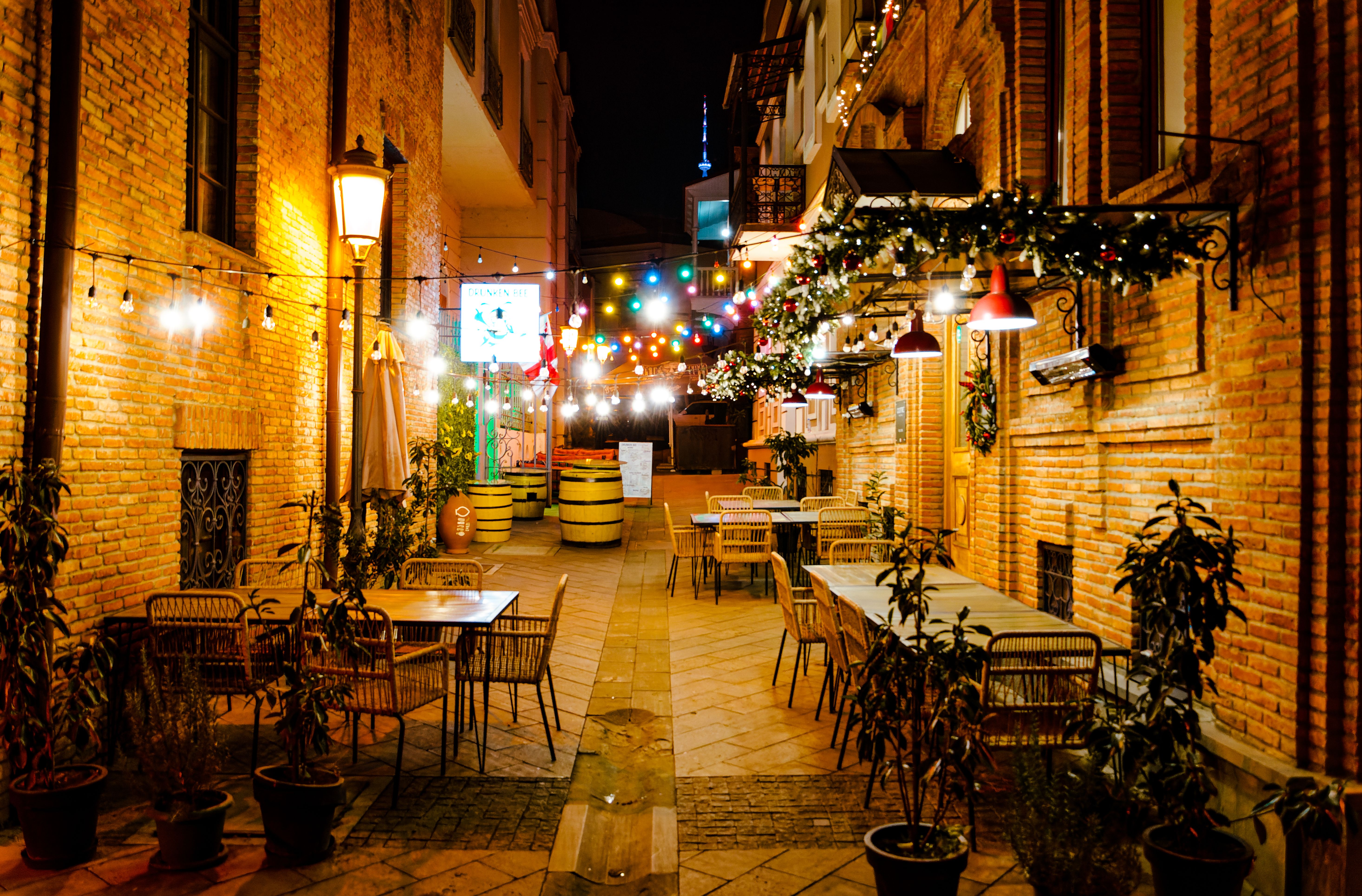Charming Outdoor Cafe at Night with Festive Lights · Free Stock Photo