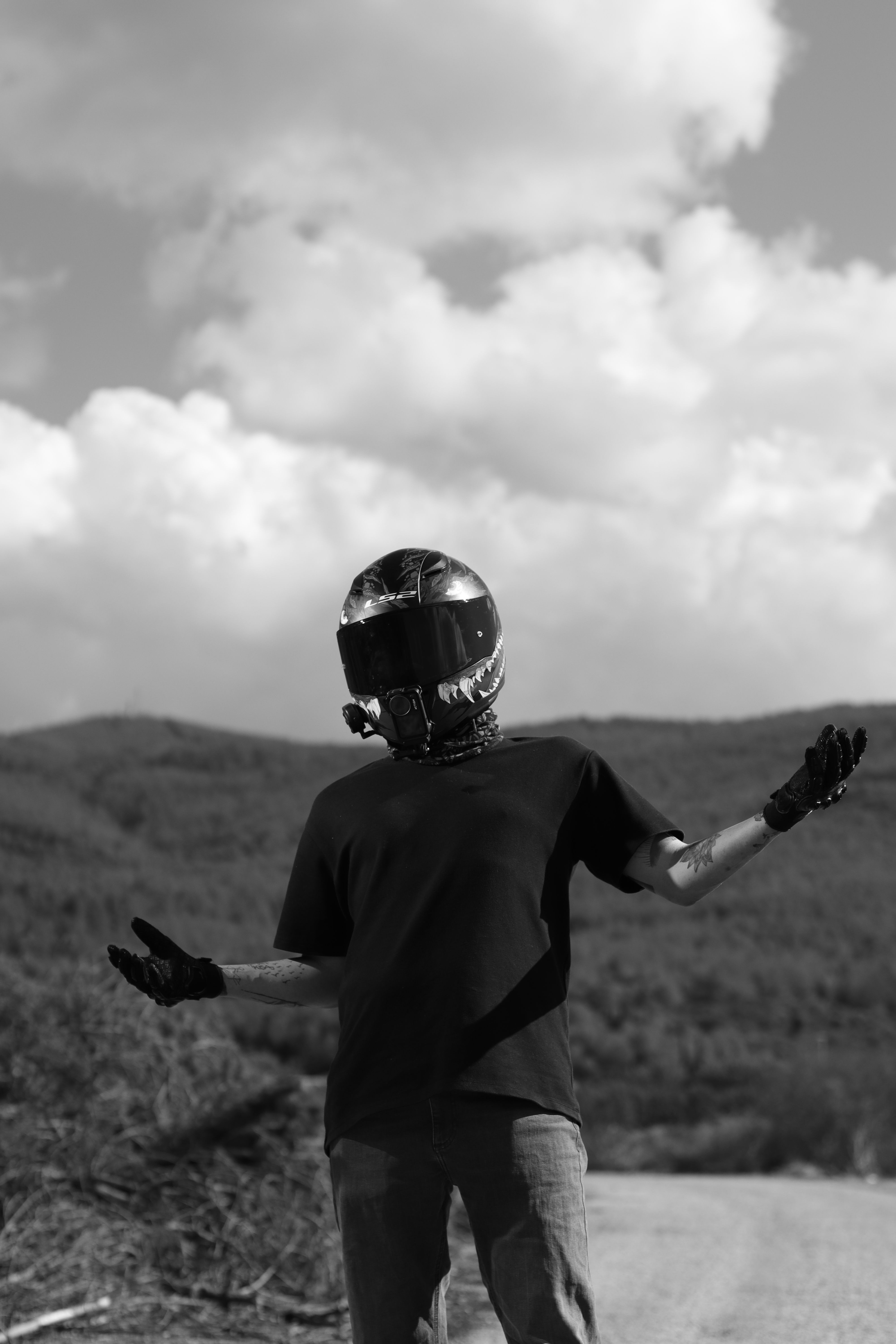 Motorcyclist in Helmet Posing on Scenic Road · Free Stock Photo
