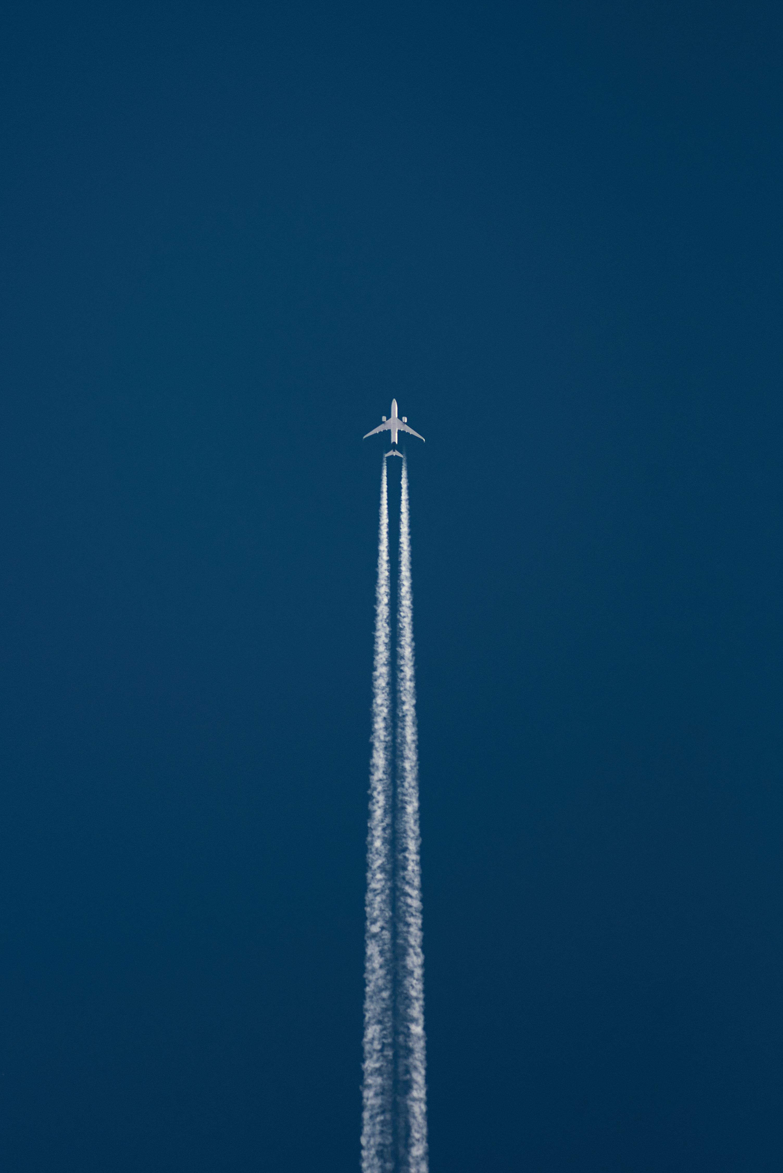 High-Flying Airplane Against Clear Blue Sky · Free Stock Photo