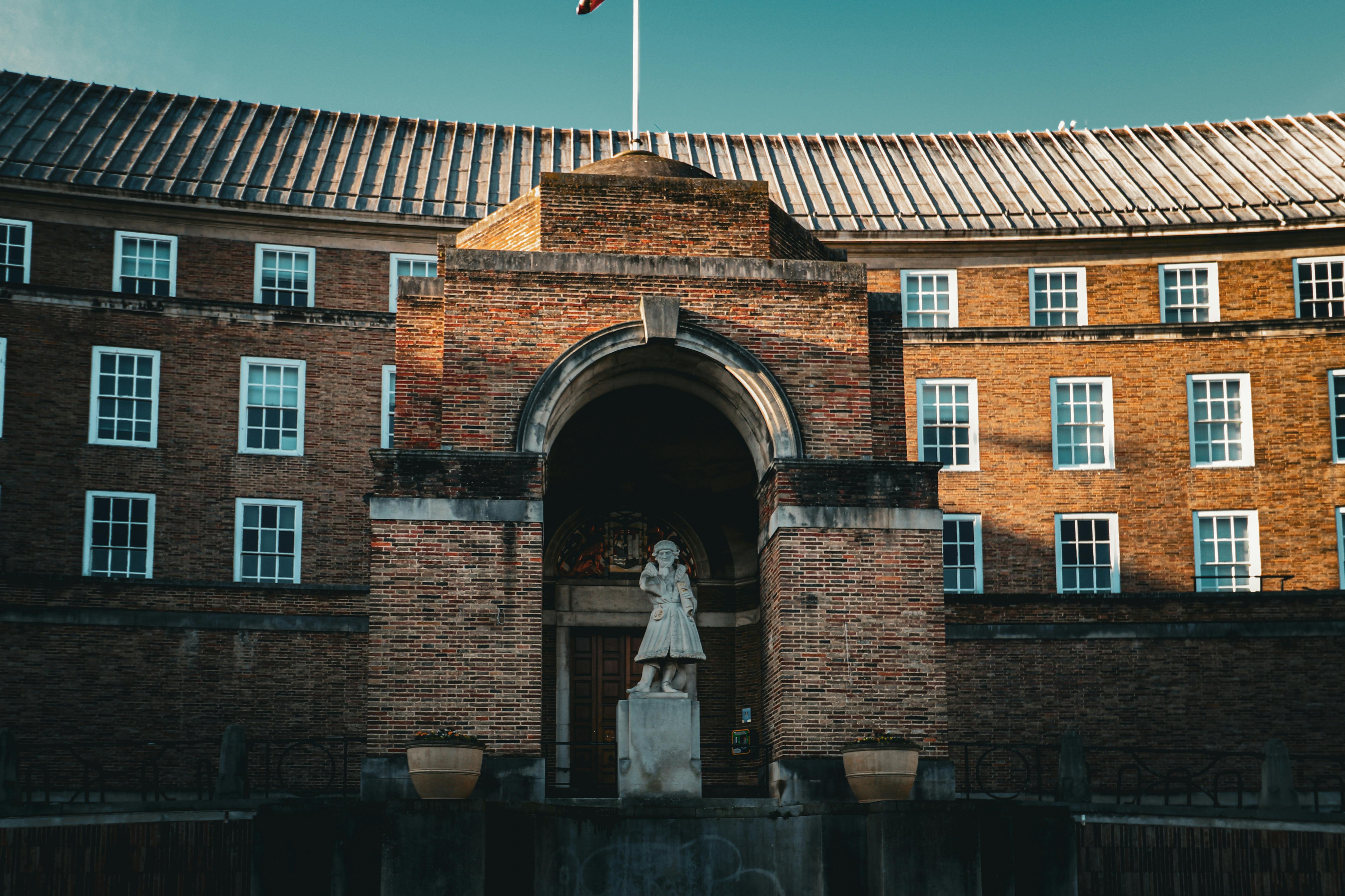 Historic Brick Architecture with Central Statue · Free Stock Photo