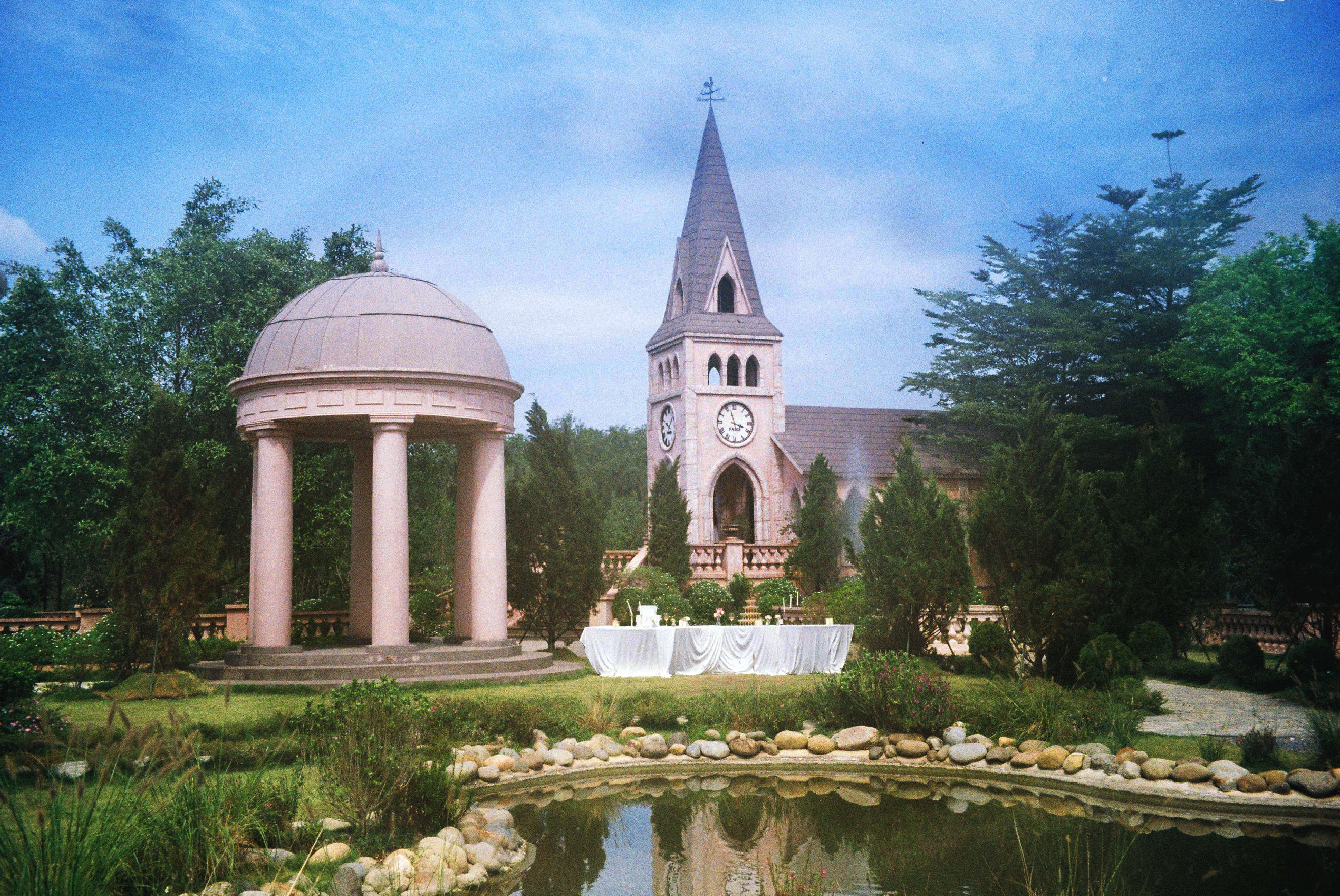 Charming Garden with Gazebo and Church Tower · Free Stock Photo