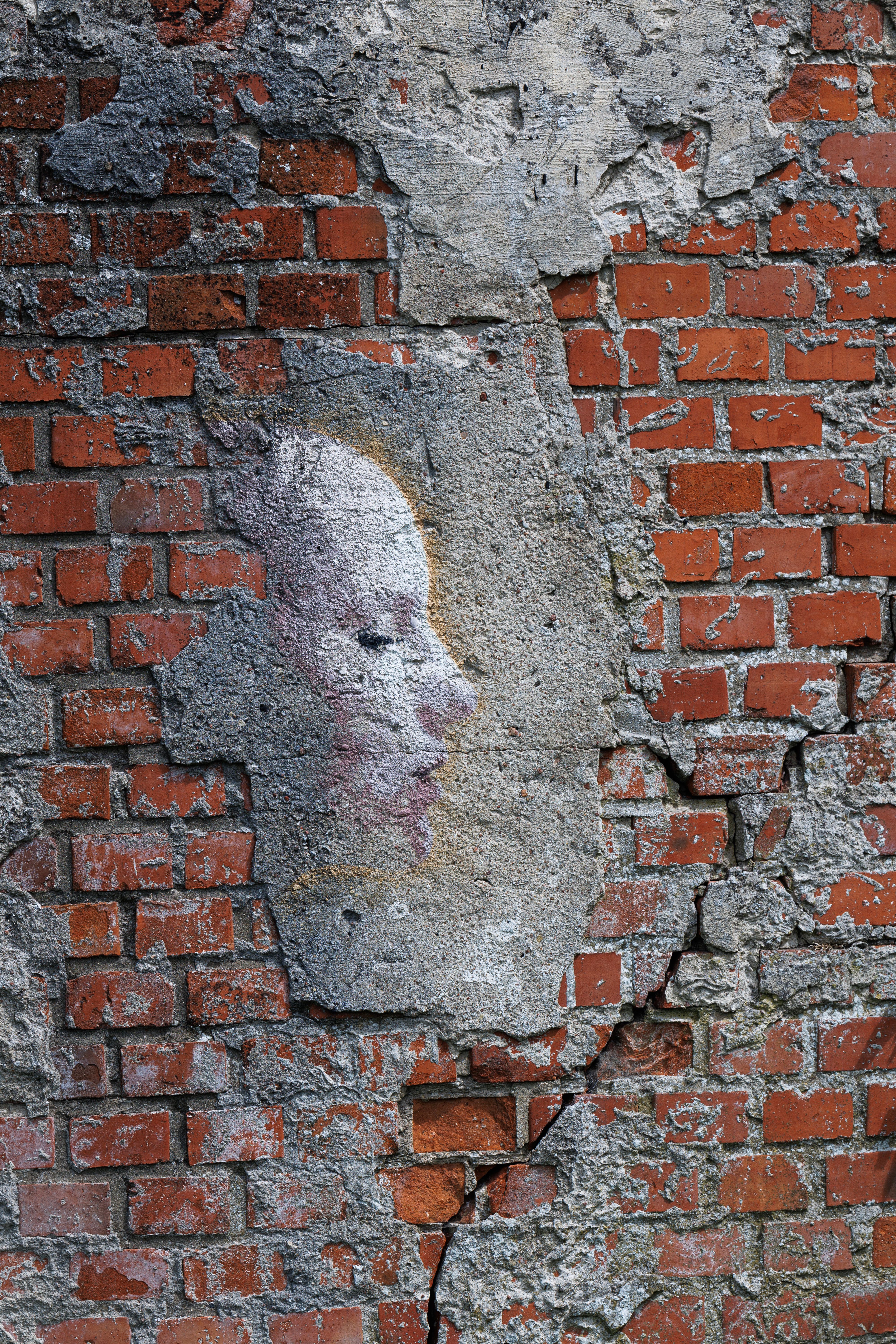Artistic Face Painting on Aged Brick Wall · Free Stock Photo