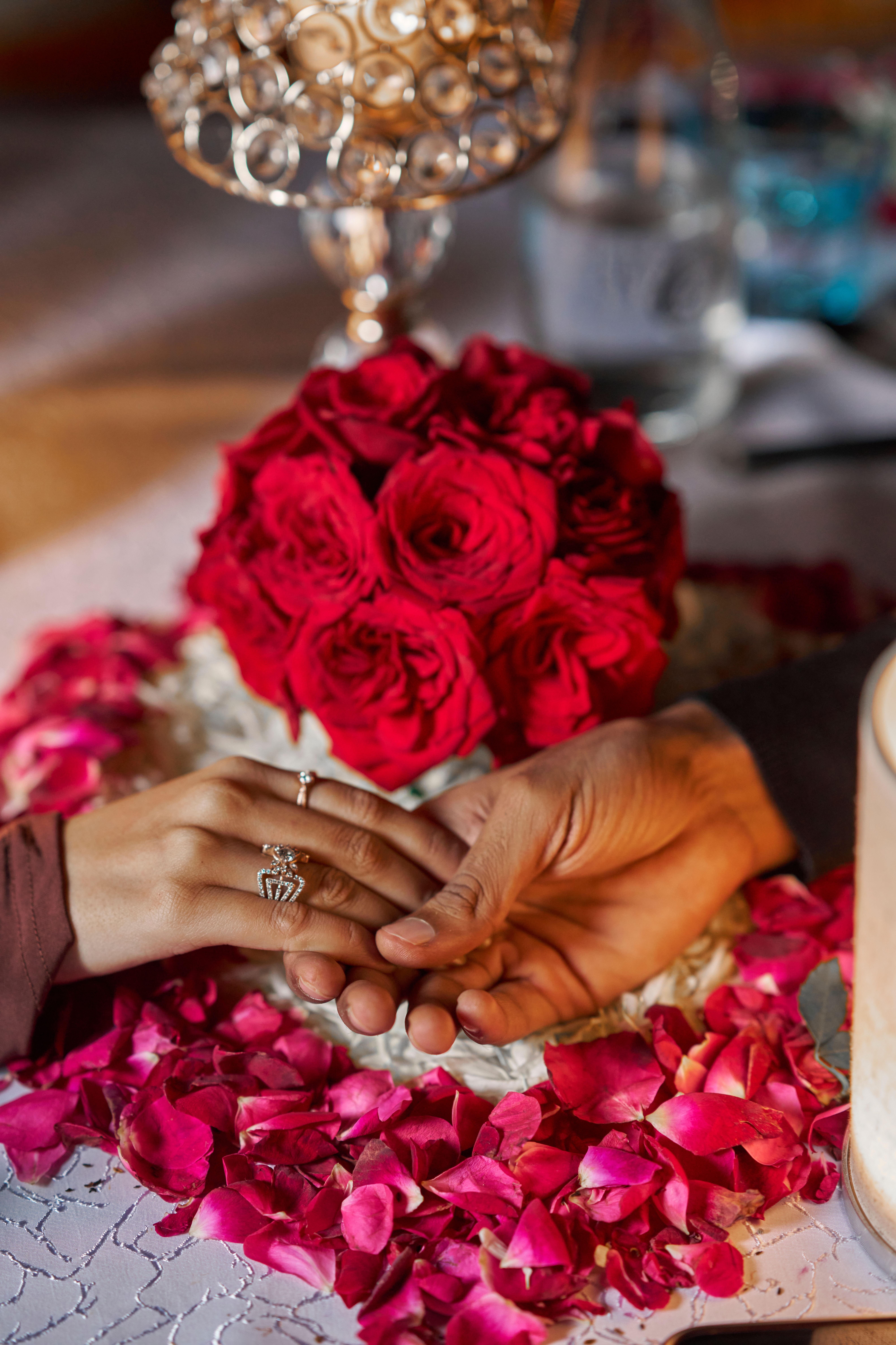 Romantic Couple Holding Hands Surrounded by Roses · Free Stock Photo